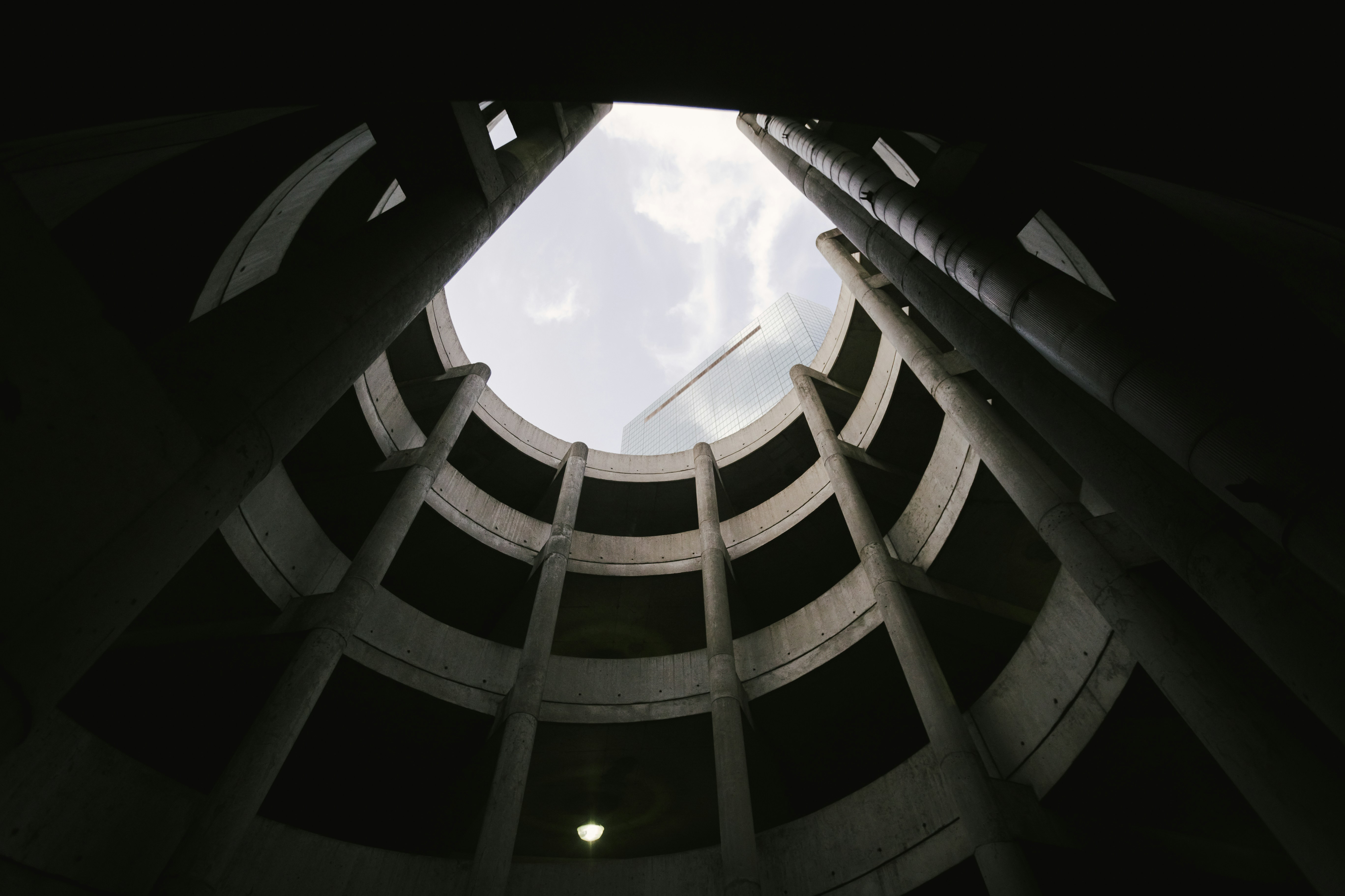 Skyward opening: circular concrete atrium framing a sliver of daylight