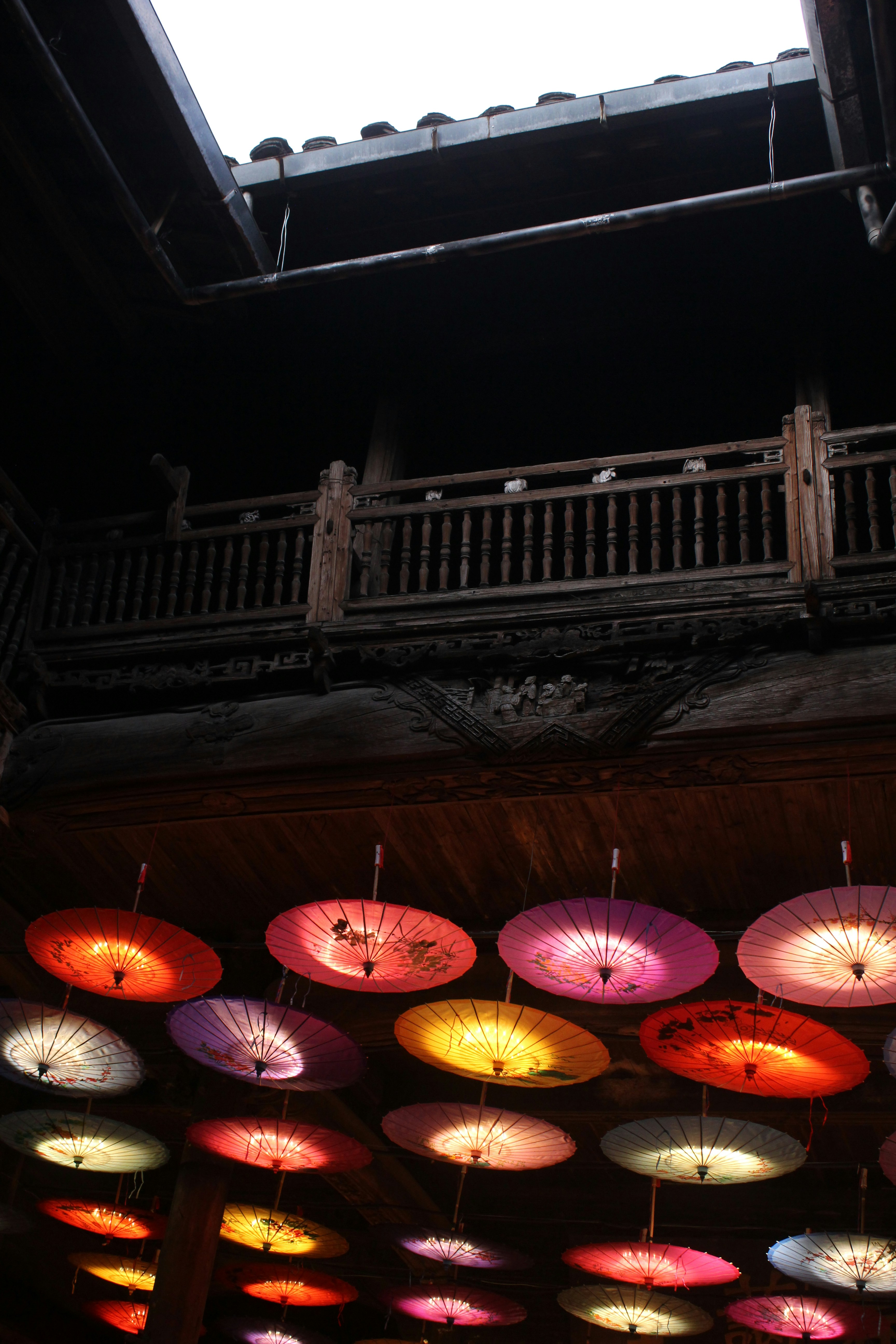 Lanterned Courtyard Beneath a Weathered Balcony