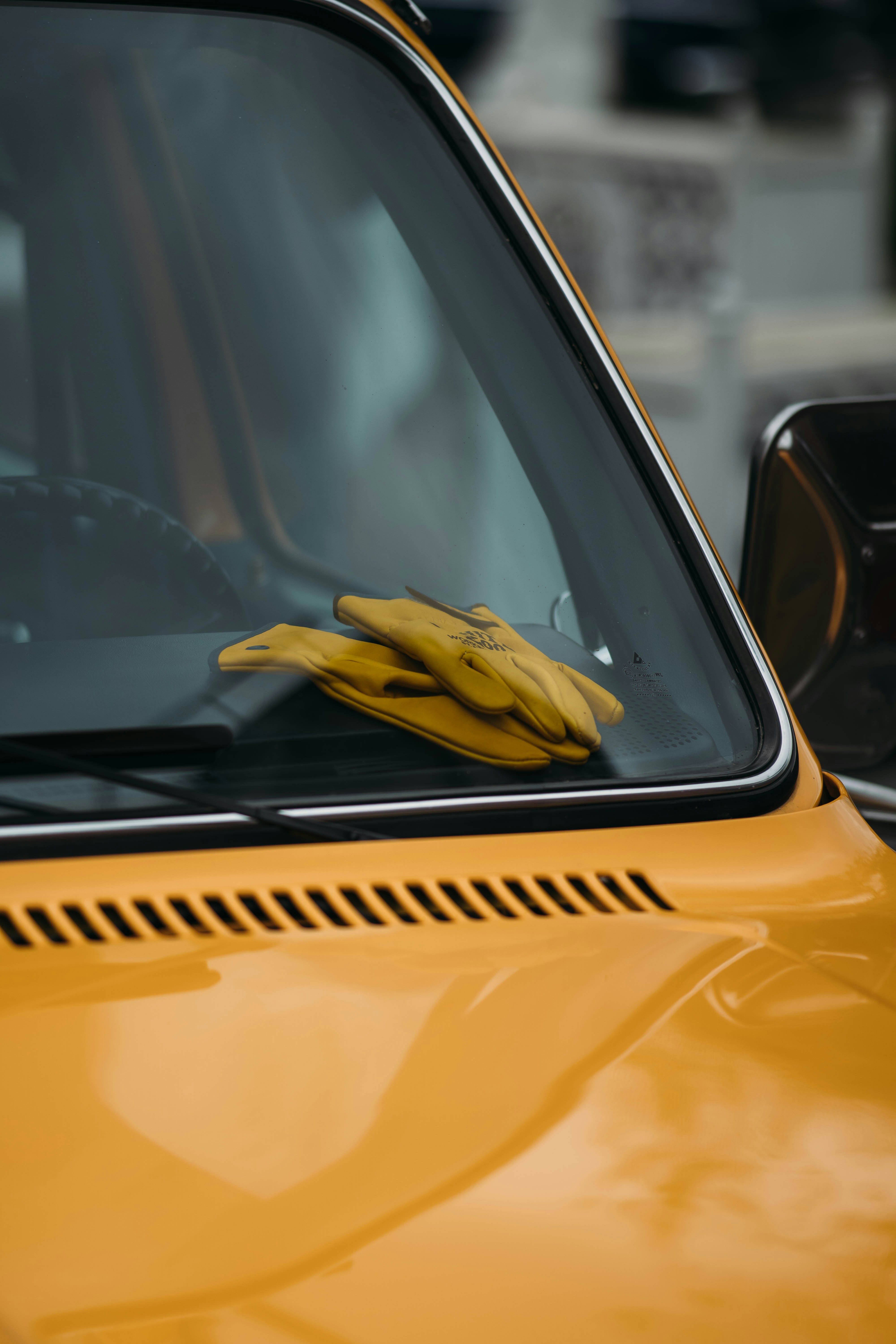 Yellow Glove on Windswept Cab: Close-Up of the Front Hood and Windshield