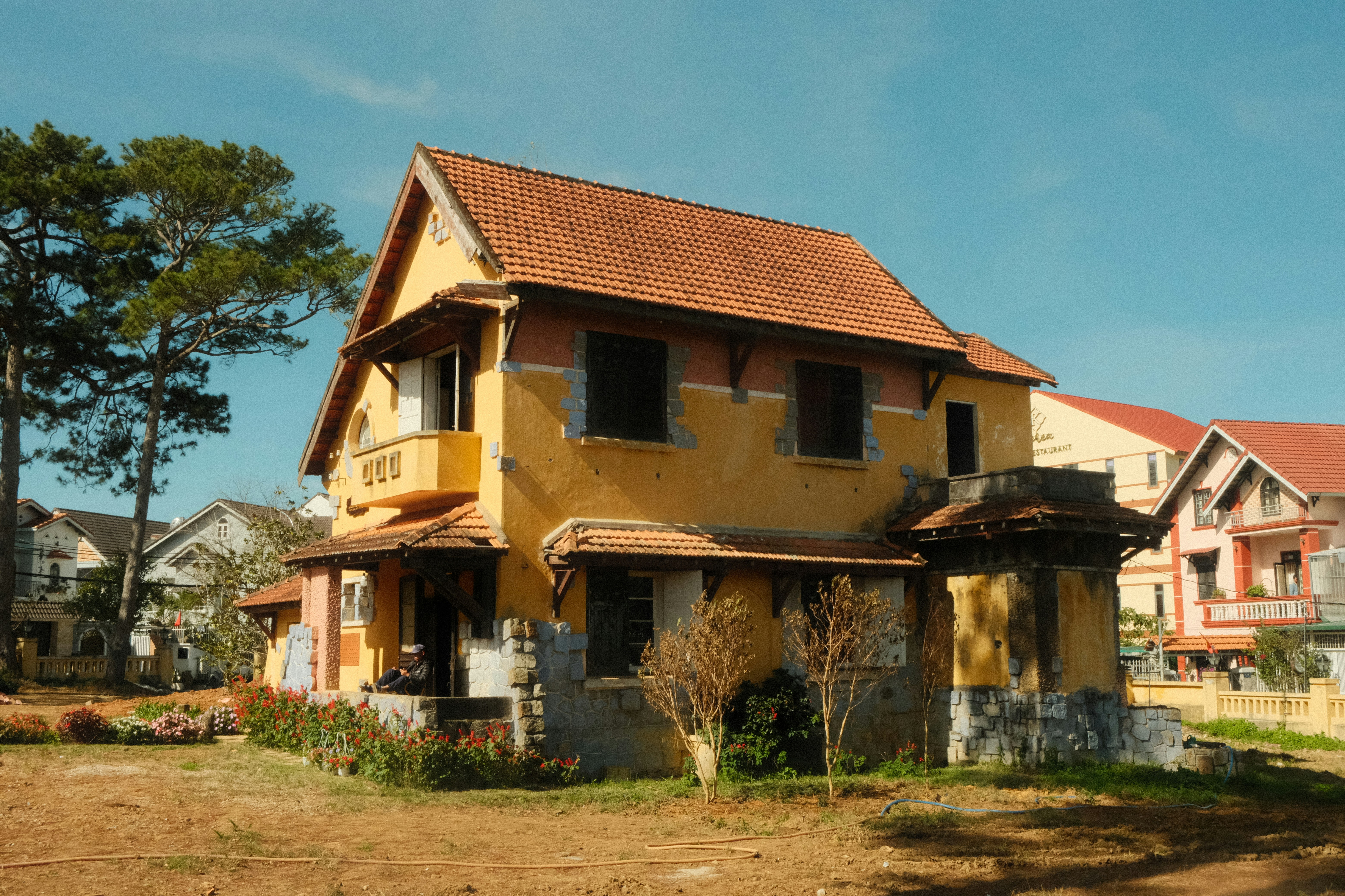 Sunlit Yellow Villa Rising from a Quiet Suburban Lot