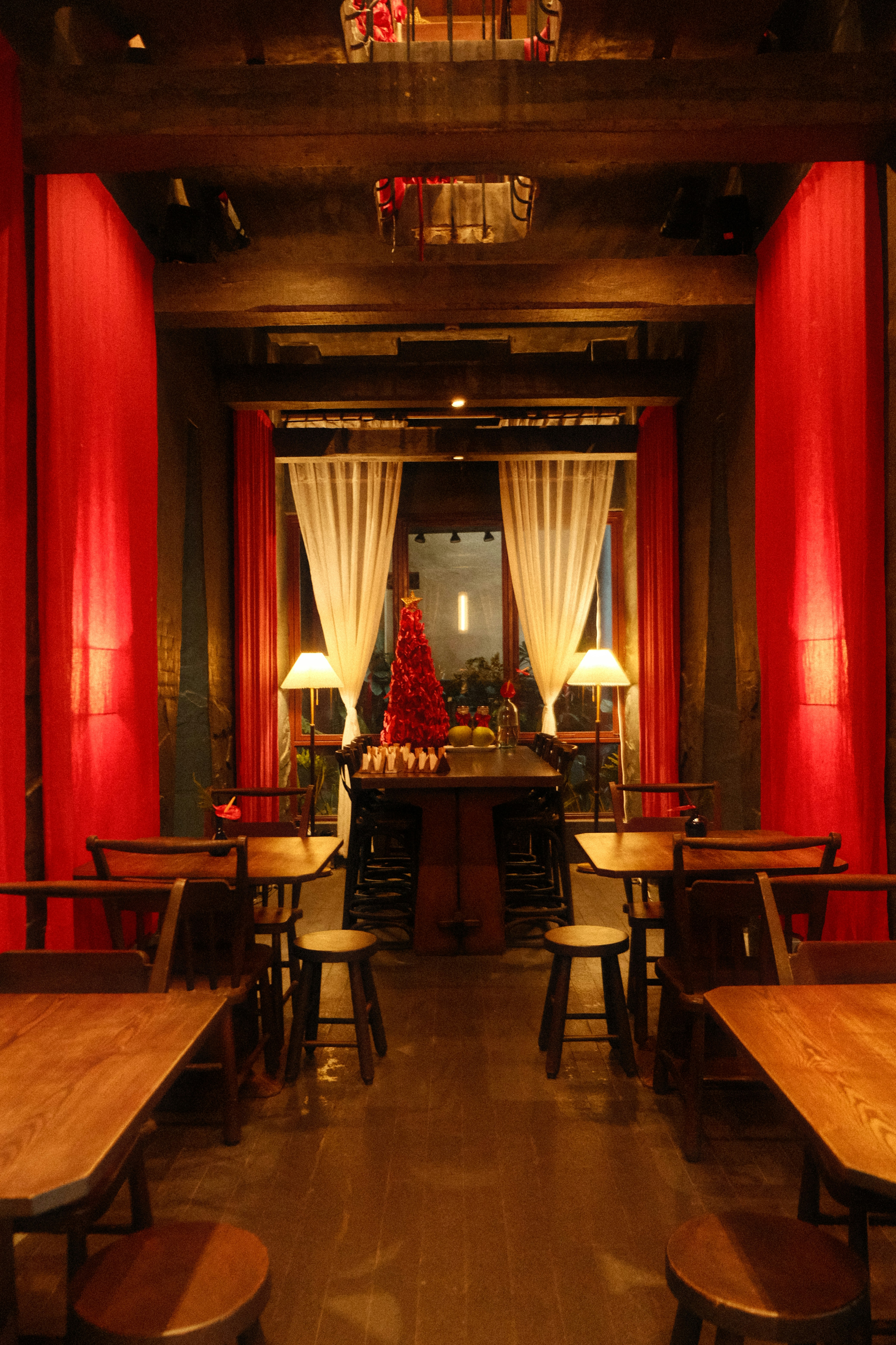 Candlelit Atrium Lounge Framed by Red Drapes