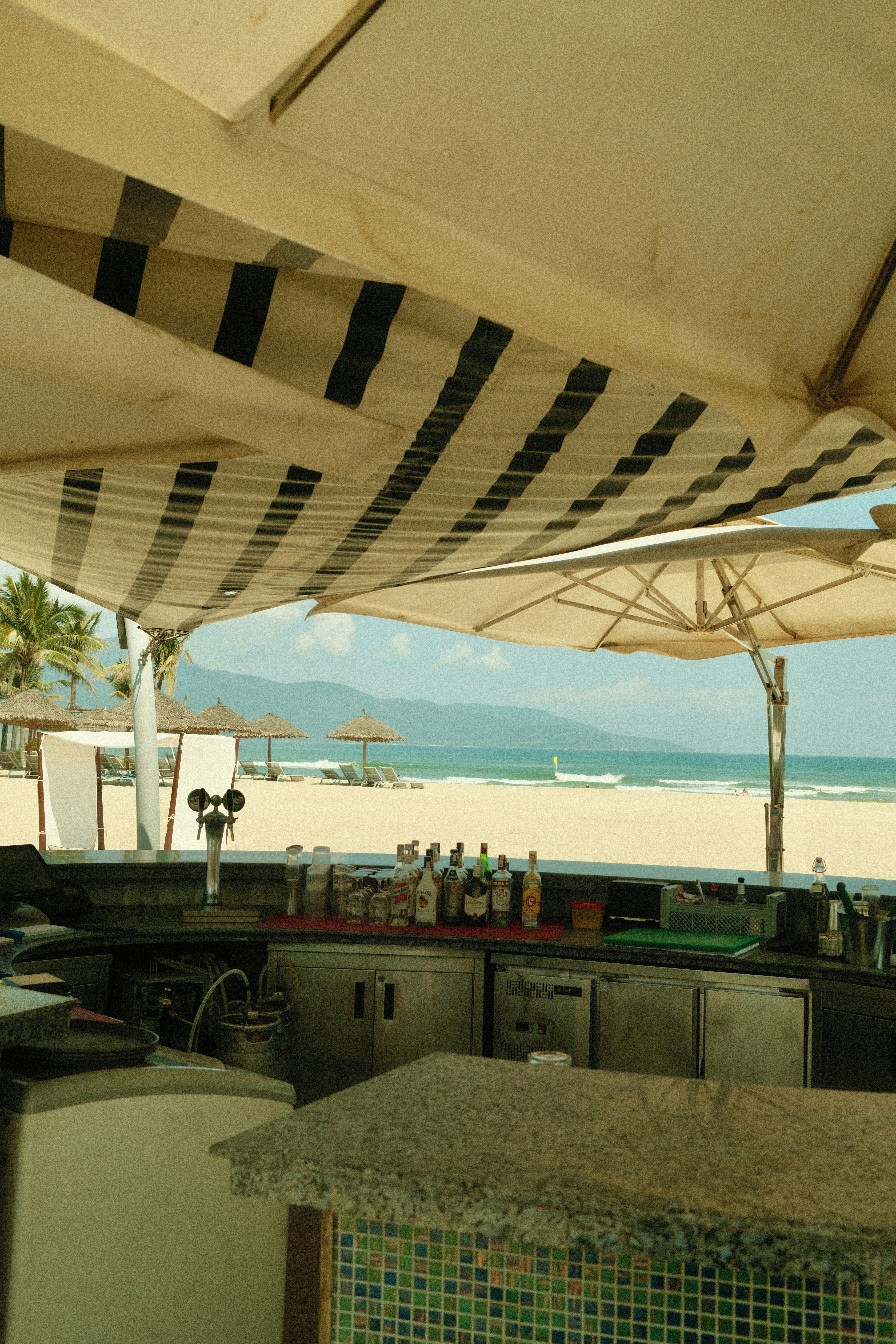 Beachside Bar Under Striped Canopy with Ocean View