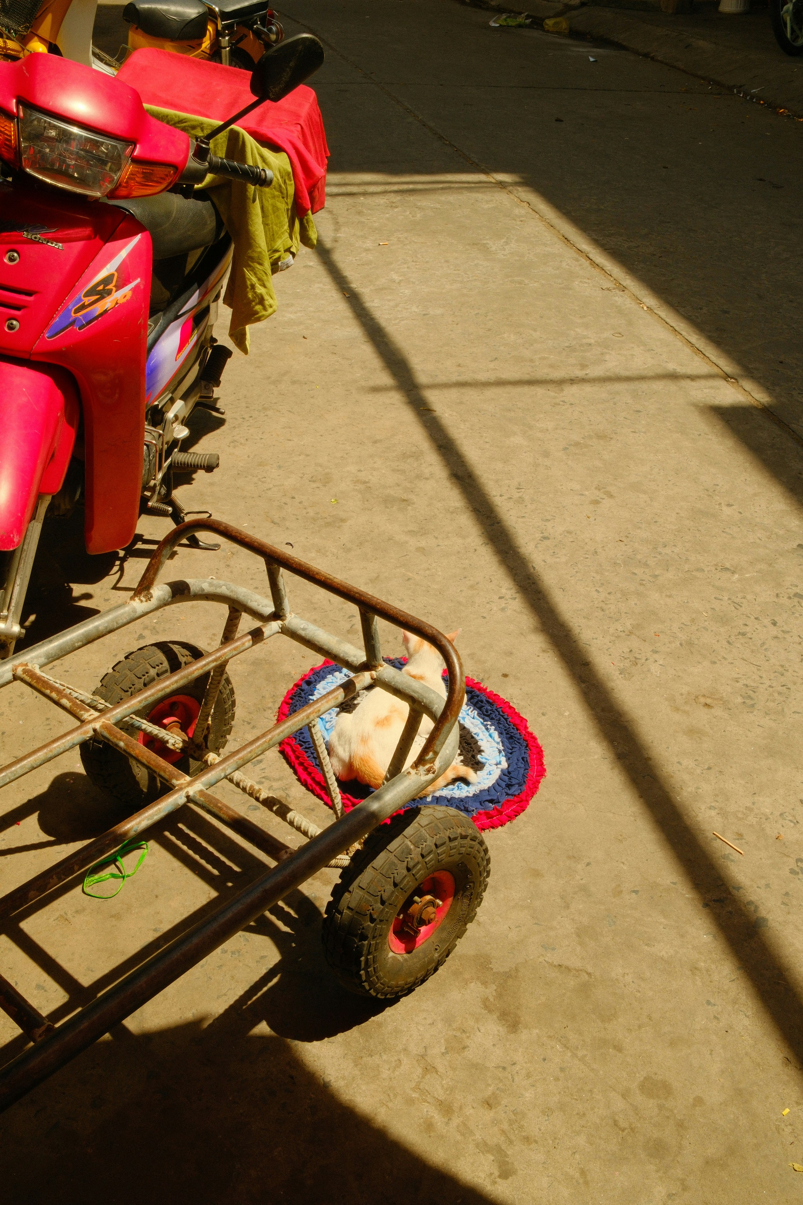Red Scooter and Shadowed Path: A Daybreak in the Street