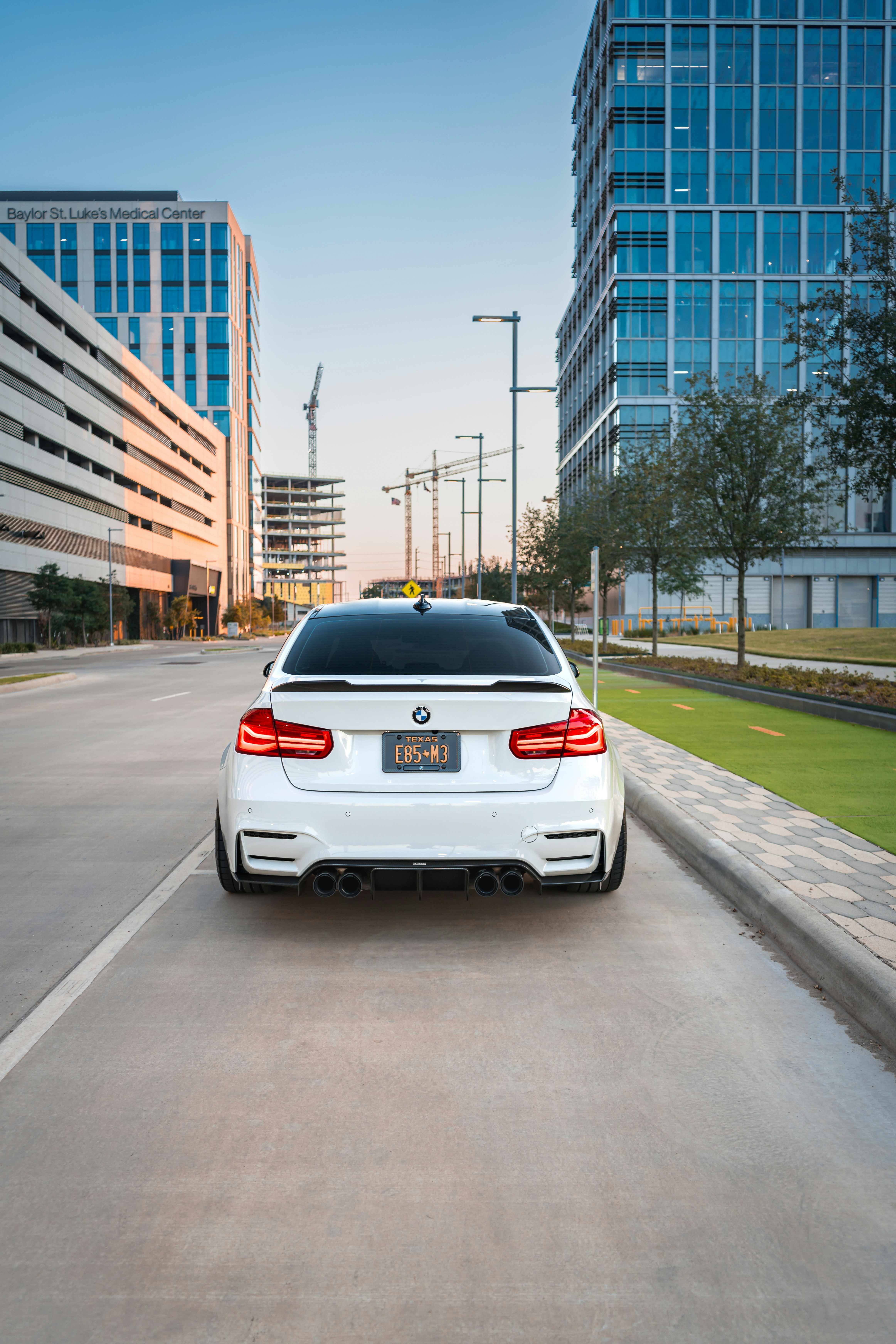 White BMW Vanishing Point: Street Toward a Glassy City