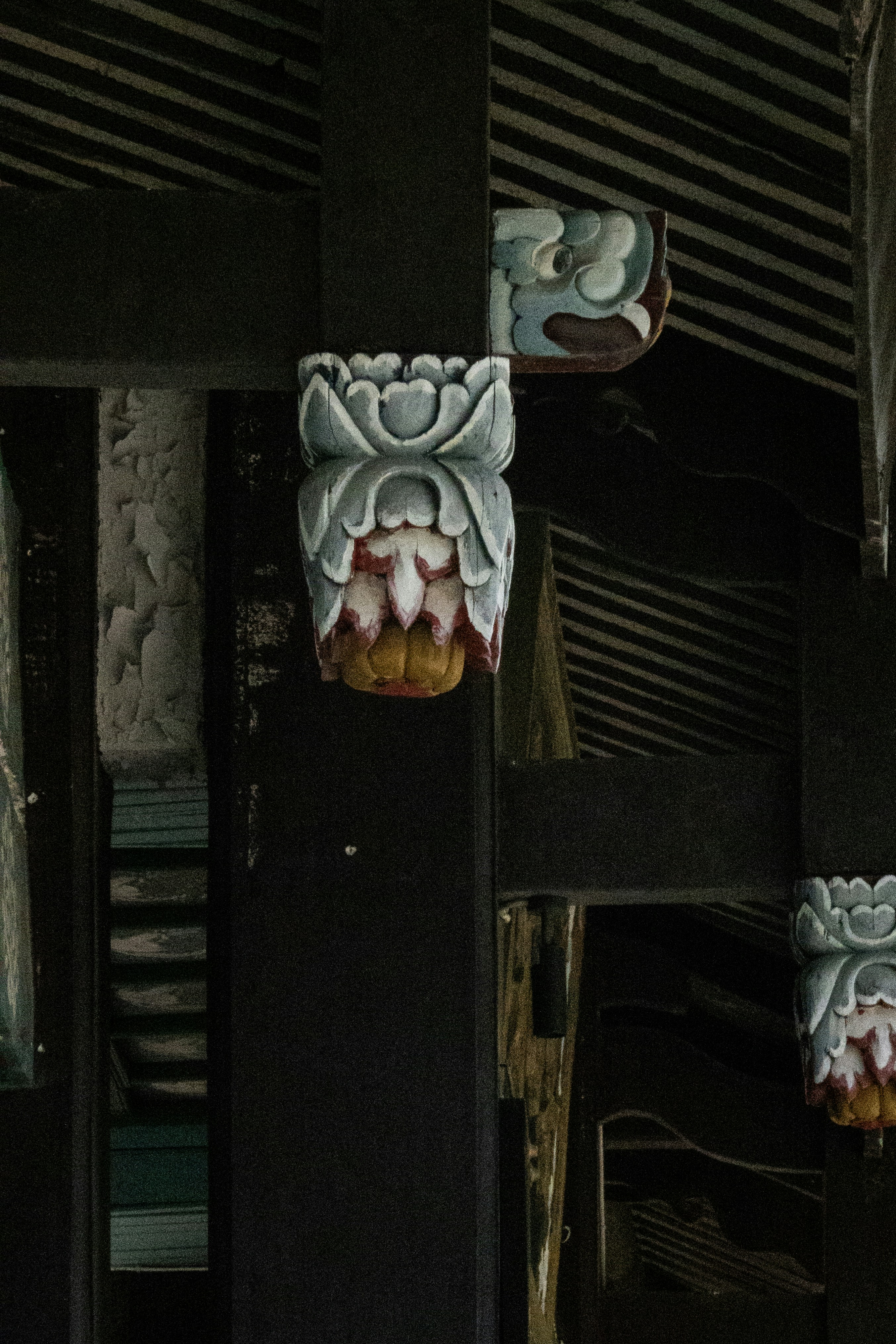 Carved beam with ornate dragon head at dusk in temple architecture