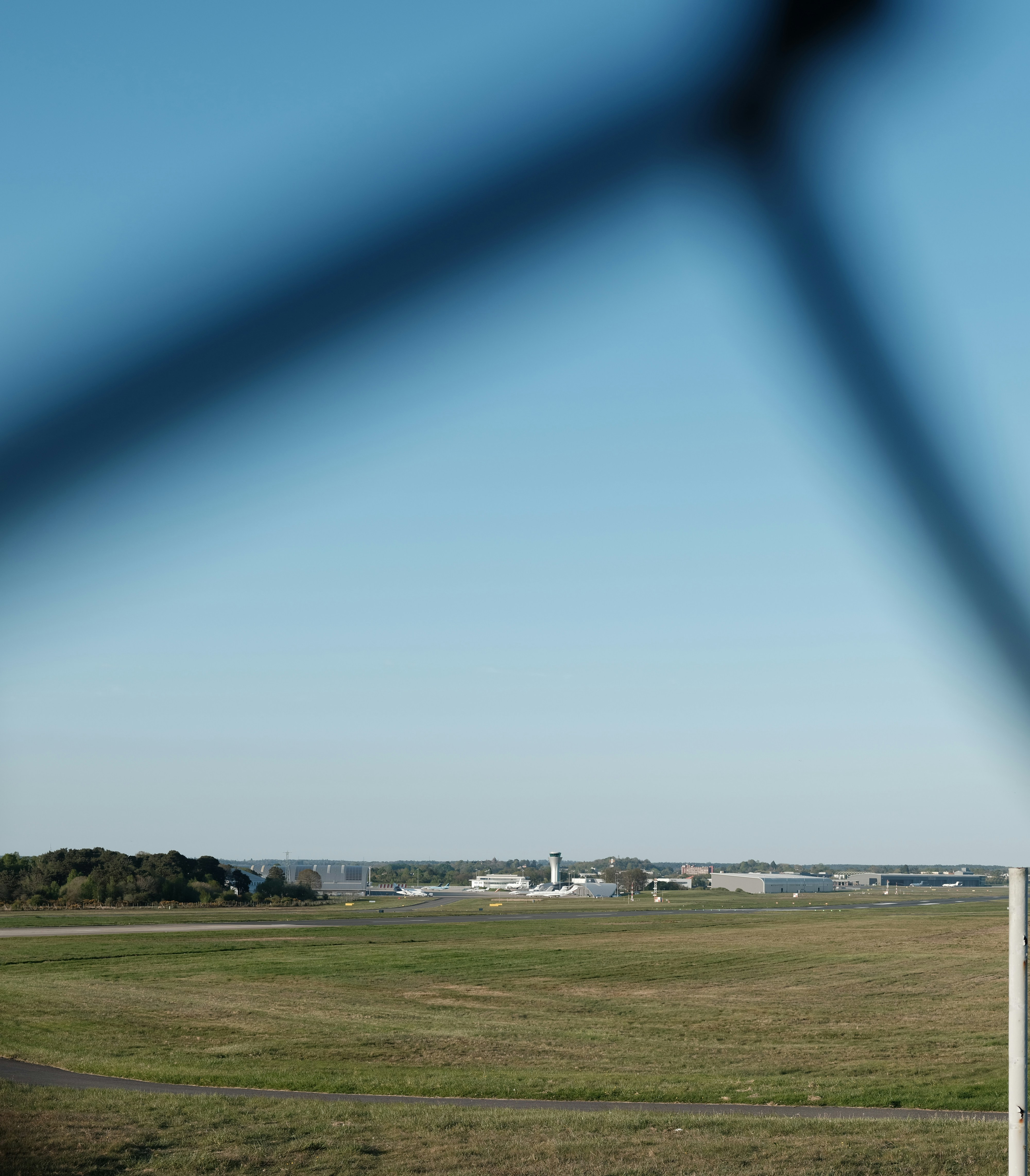 Airfield Horizon: Blurred Structure Crossing a Quiet Field