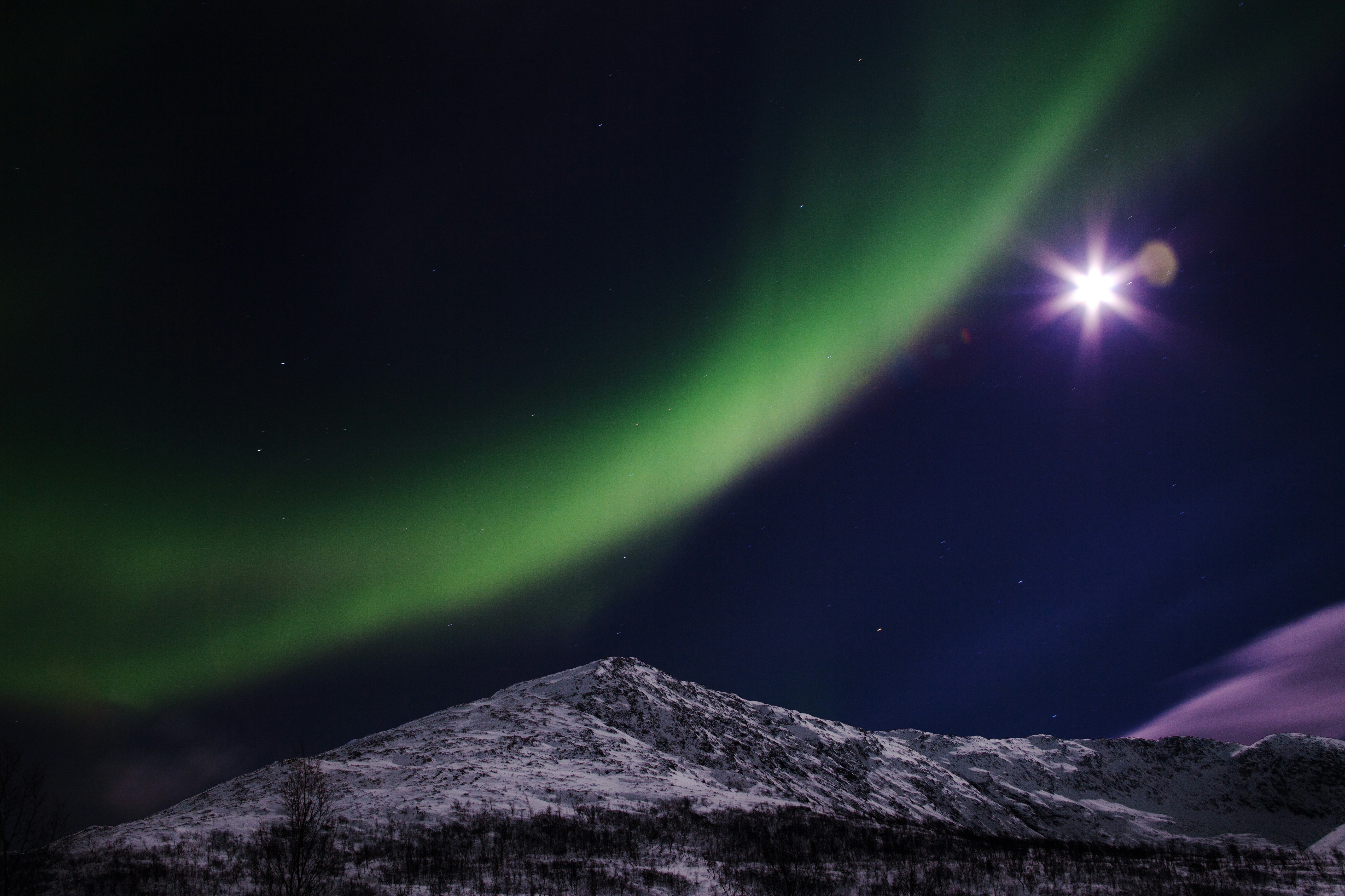 Aurora Ribbon Over Snow-Topped Ridge Under a Sharp Crescent Moon