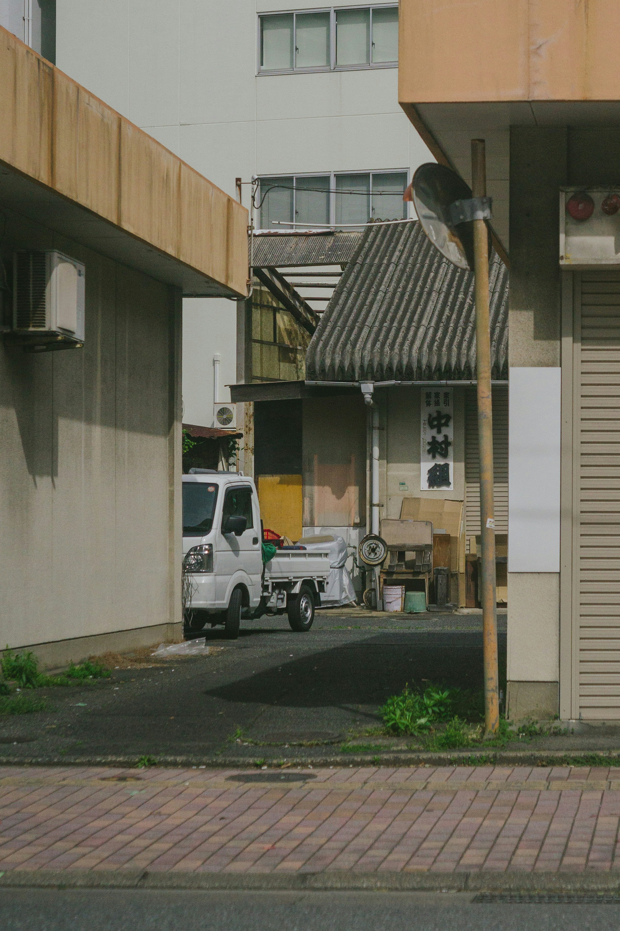  Alleyway Between Industrial Facades with Aerial of a Shaded Courtyard 