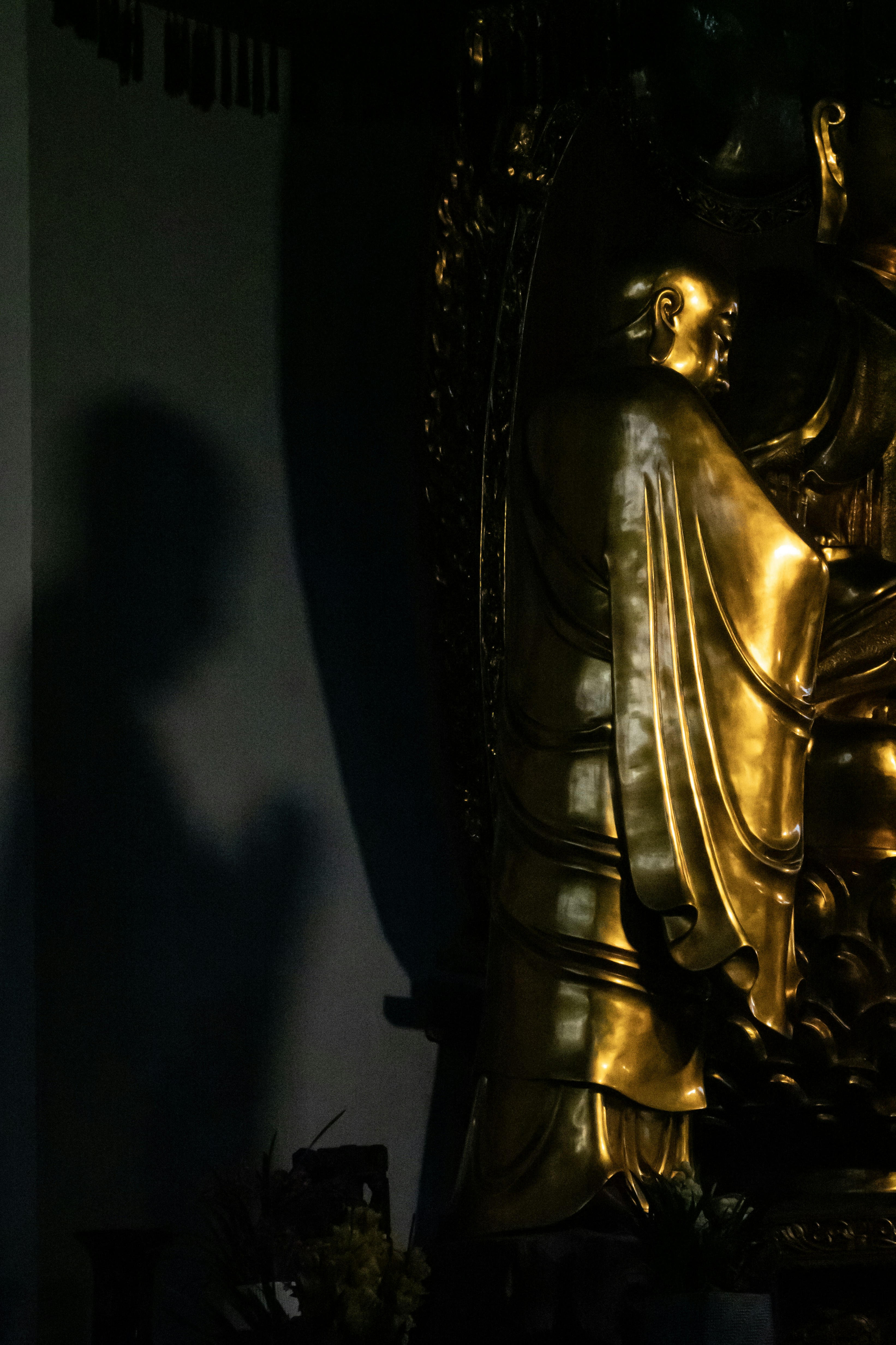 Golden Aura: A Quiet Moment with the Statue's Gilded Drapery