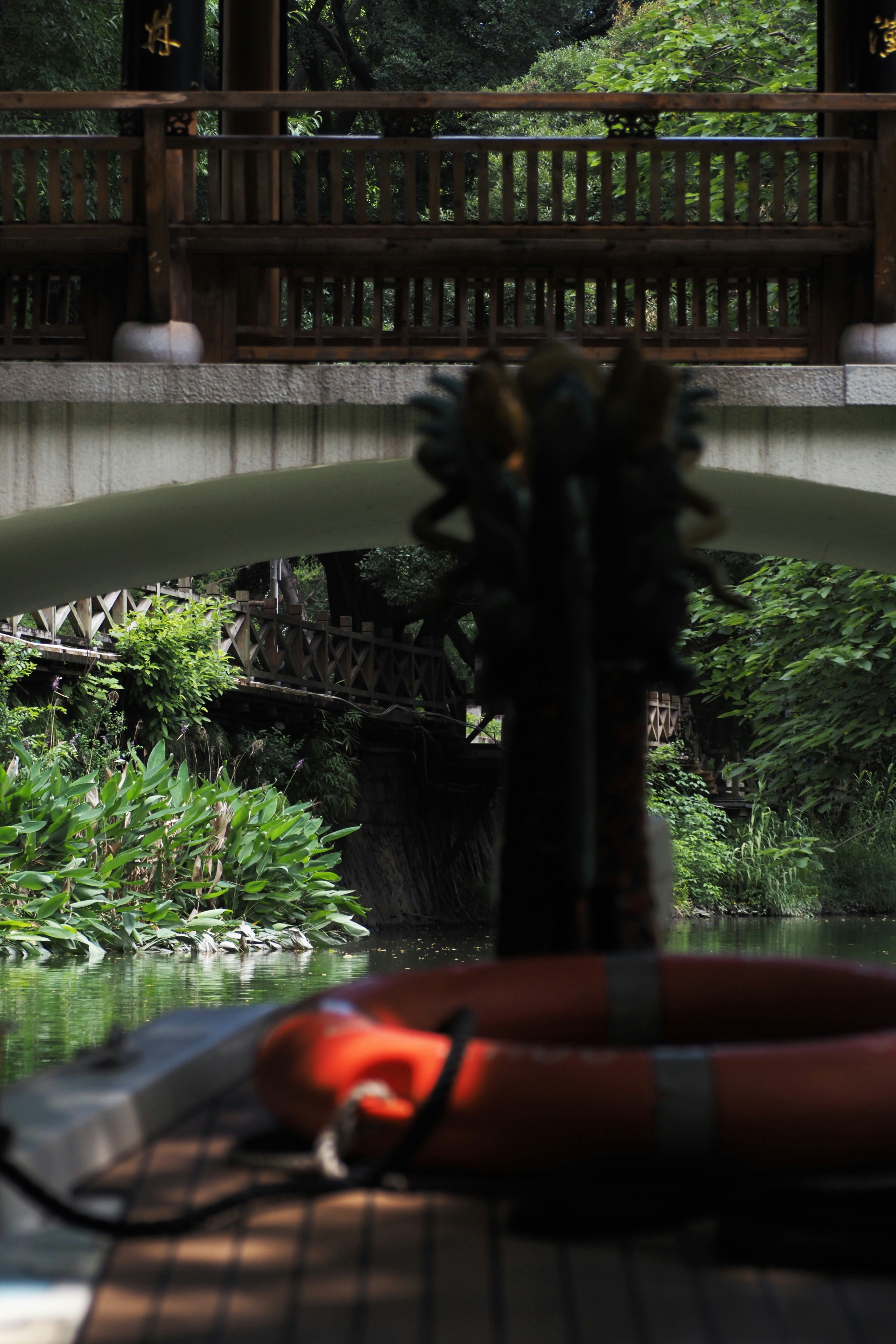 Suspended across the river, a quiet lifebuoy guards the blurred foreground