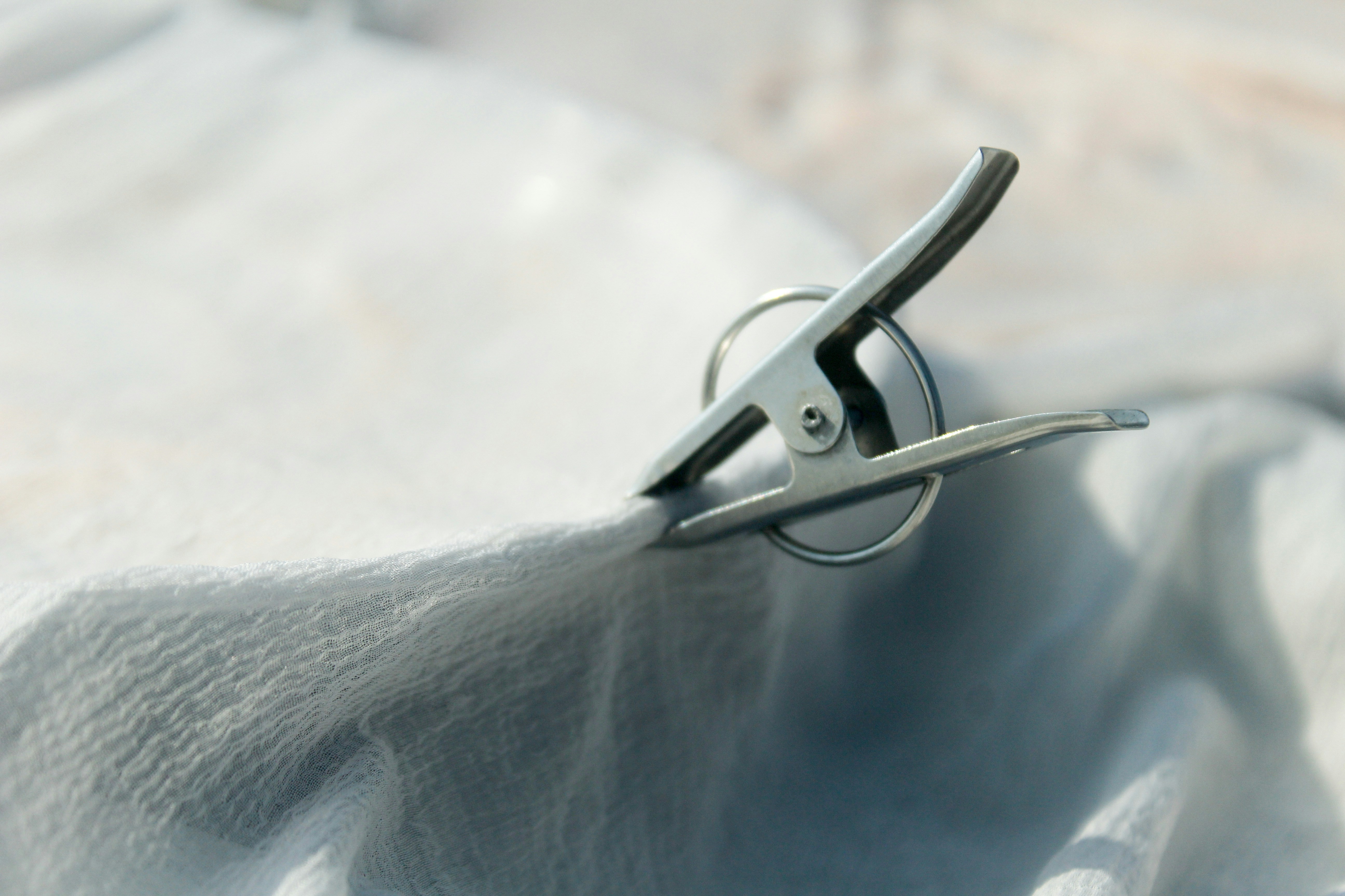 Pinned Moment: A Sharp Metallic Clasp on Soft Fabric