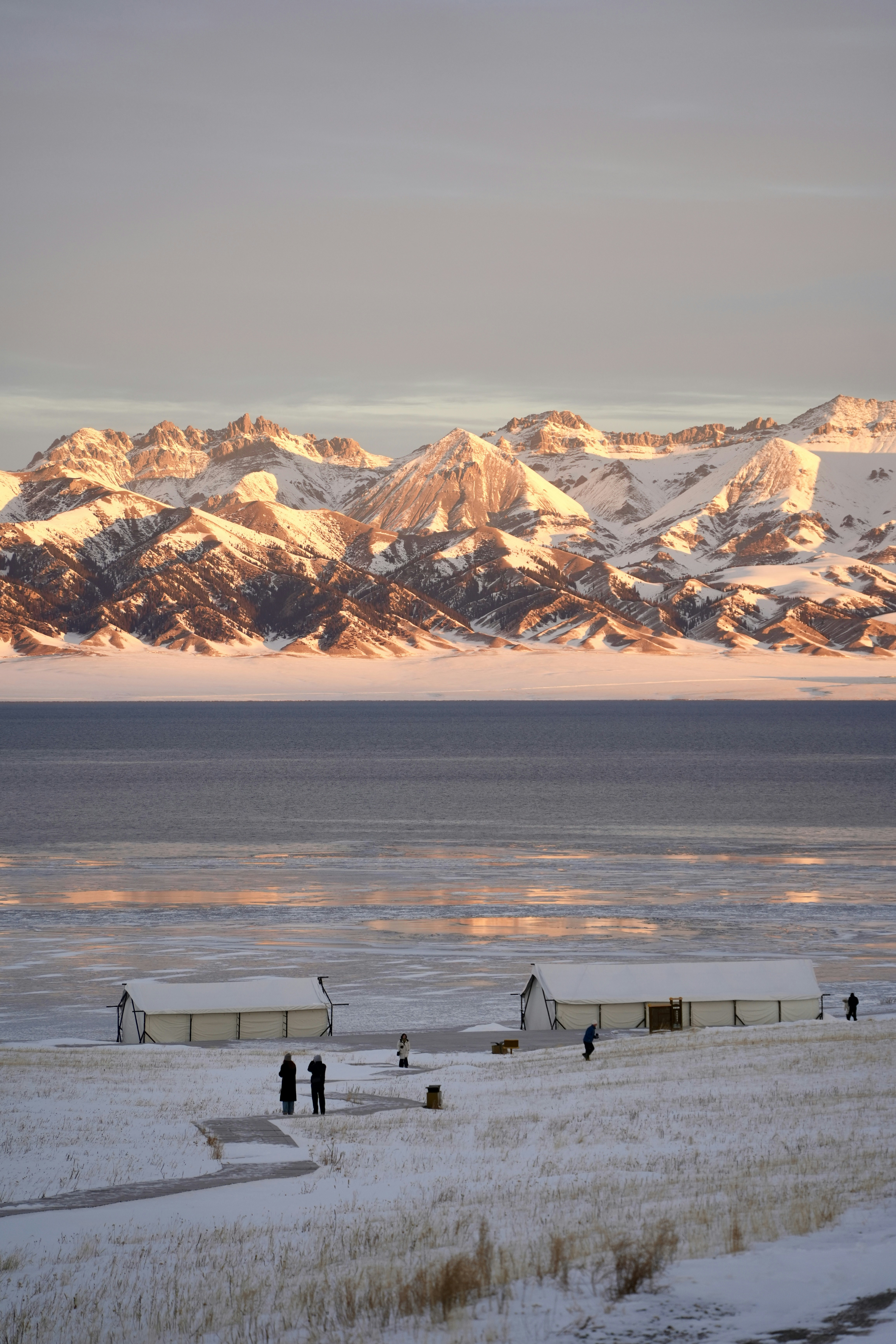 Snowbound Serene: Campsite Hues Beneath Golden Peaks
