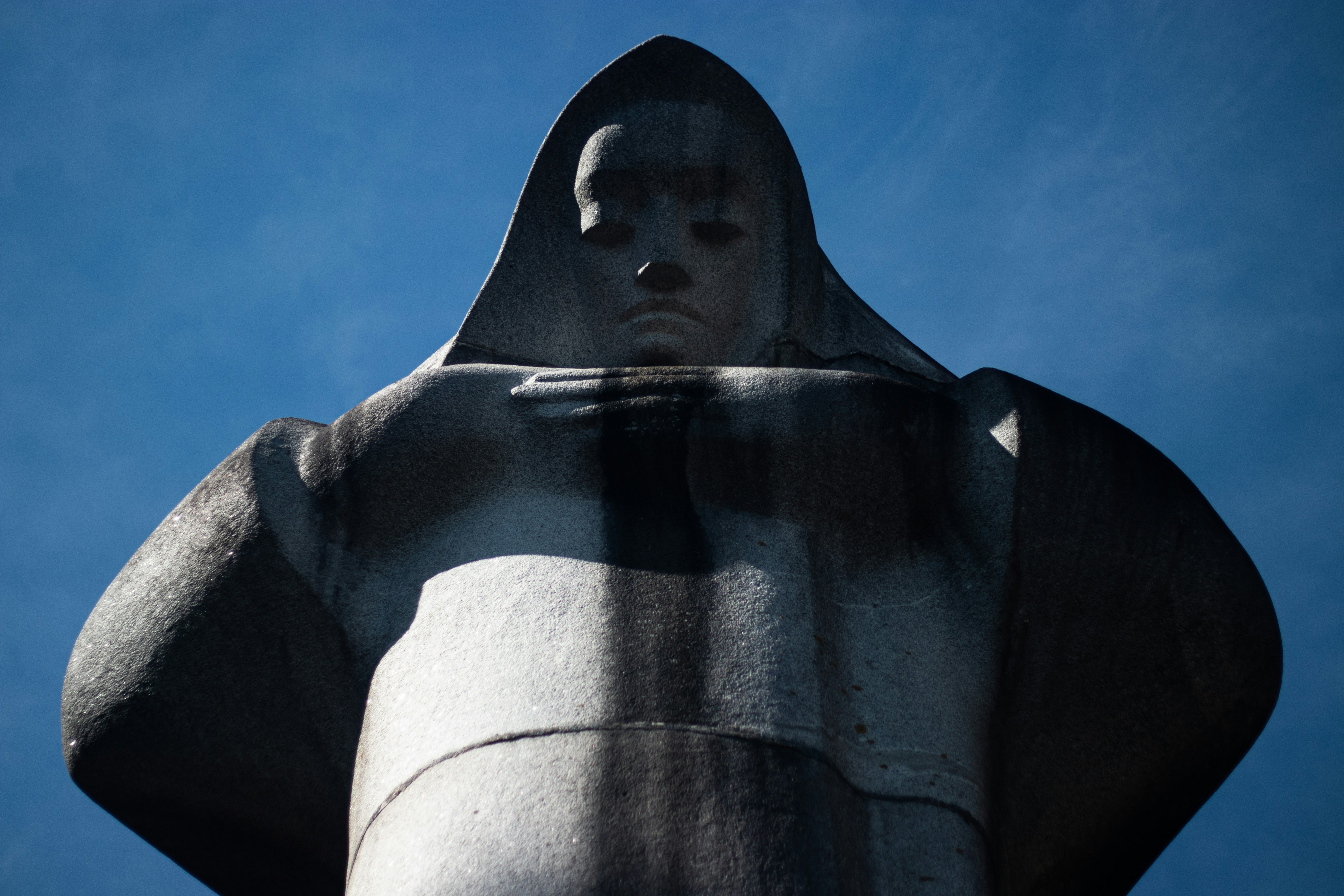 Umbra of the Monument: A Stoic Figure against a Clear Sky