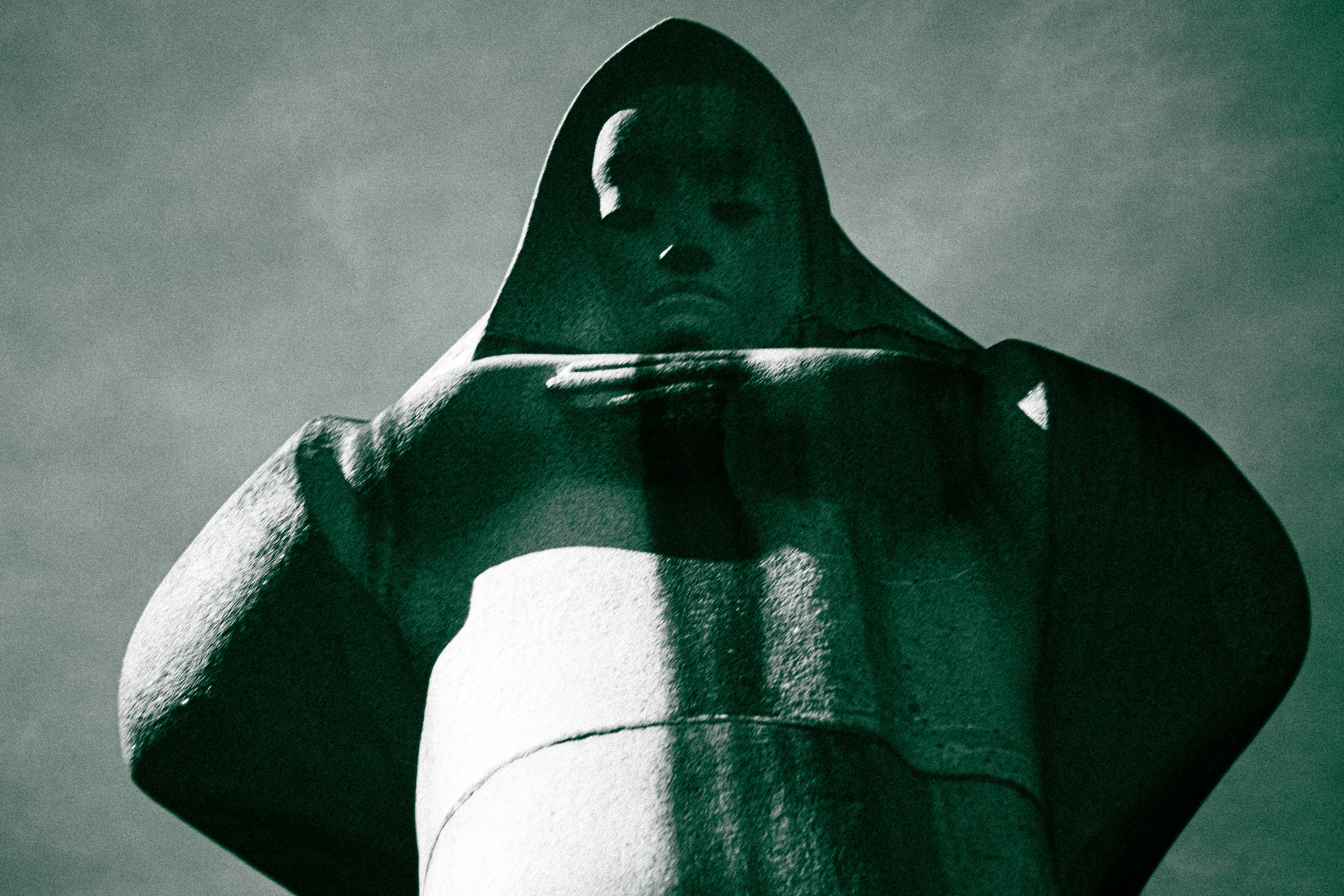 Monolithic Shadow: A Verdigris Vigil in Stone