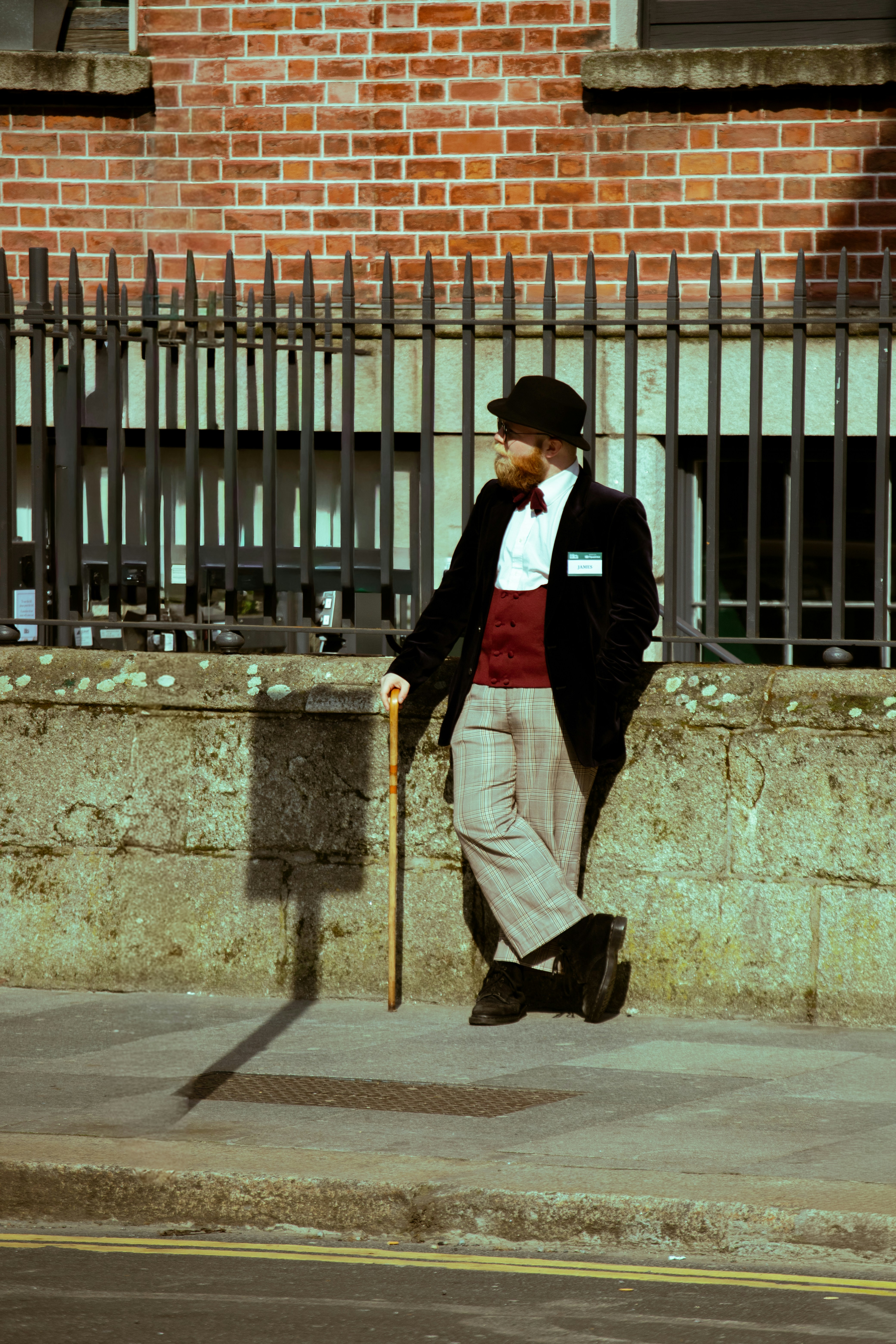 Gentleman in vintage attire leans against city railing