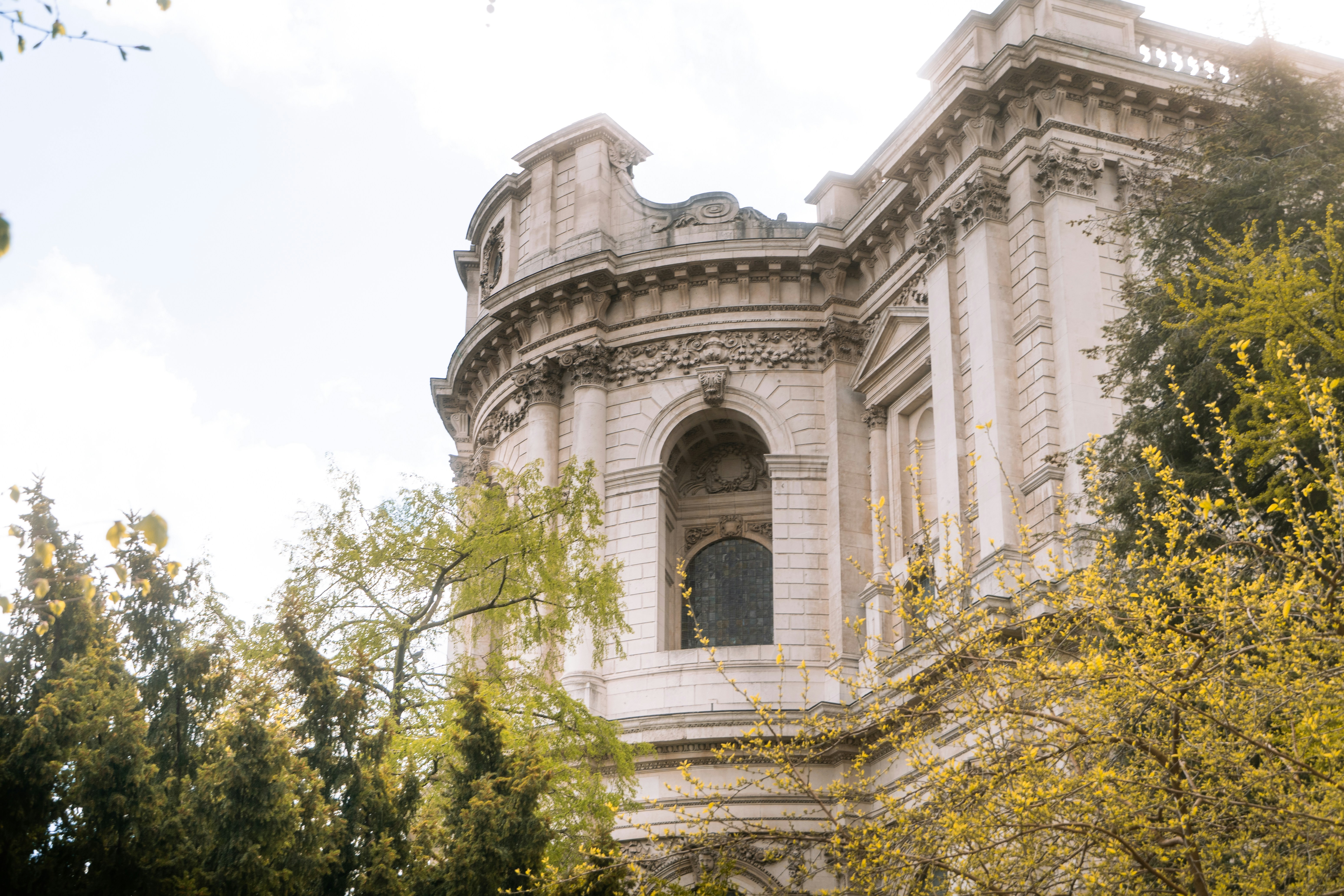 Ornate Beaux-Arts Facade Emerging Through Spring Foliage
