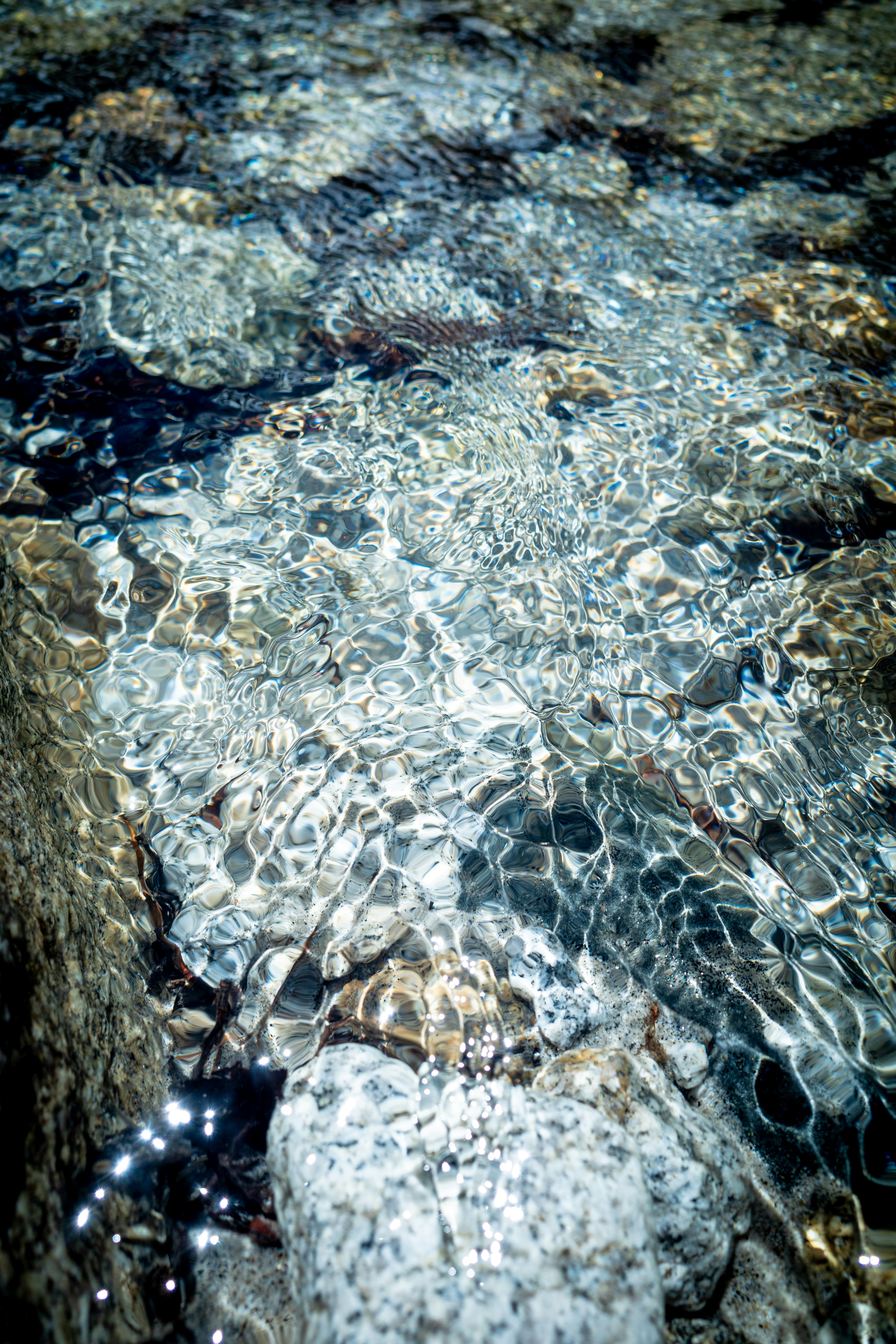 Ripple-kissed Tide: Granite Bed Beneath Shimmering Water