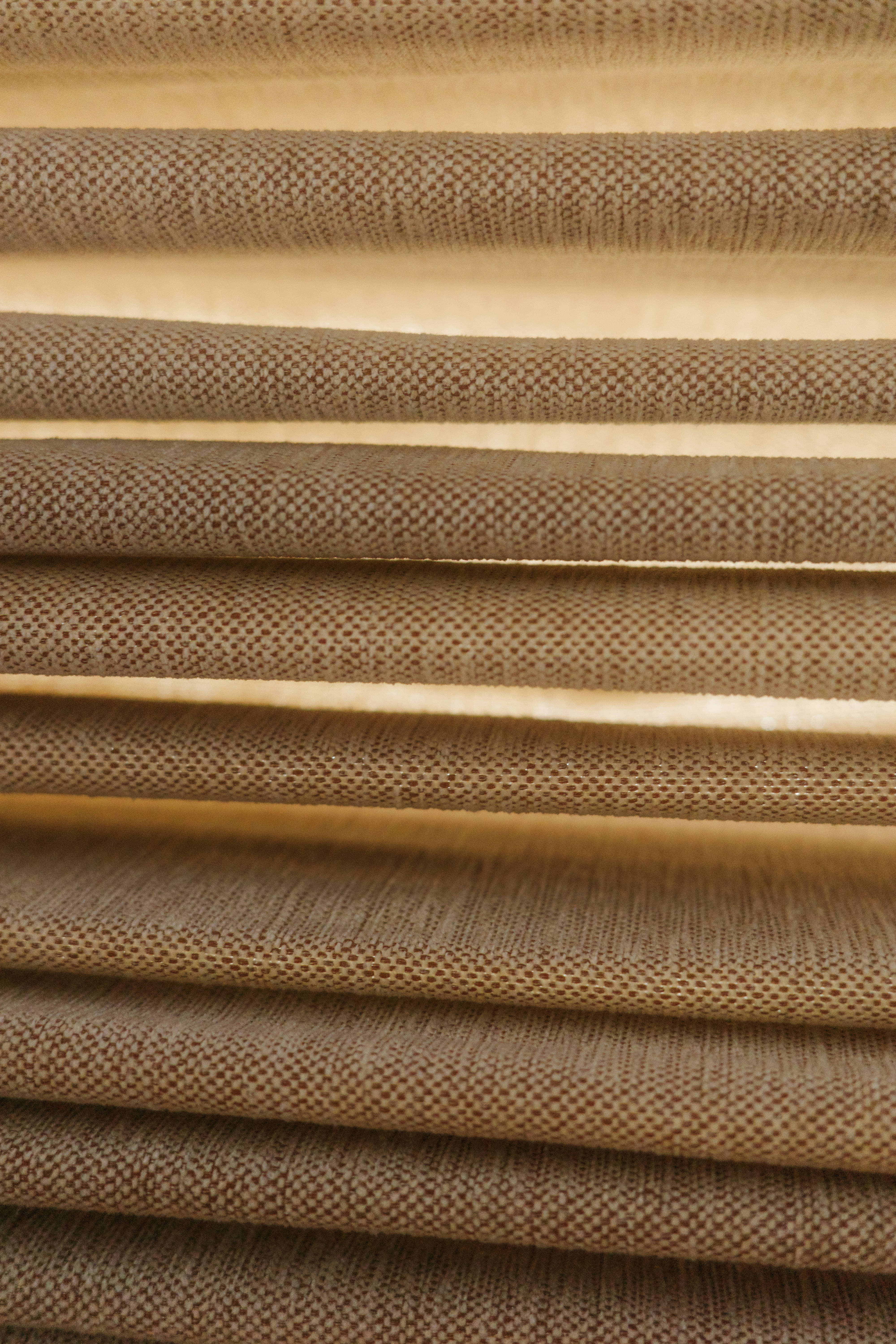 Close-up of textured fabric folds: a warm, layered tapestry of burlap-like weaves