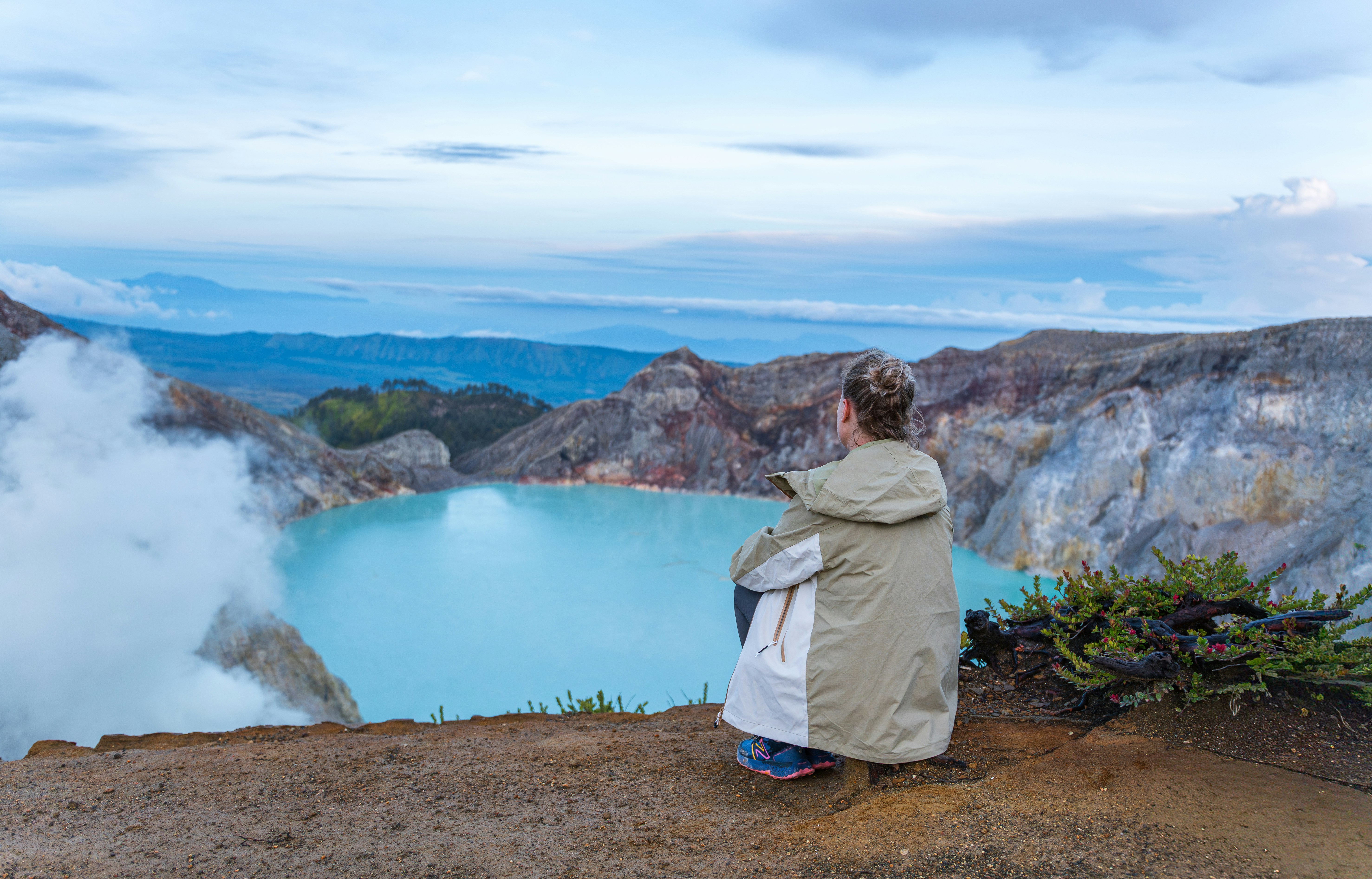 Cliffside contemplation above a turquoise crater lake