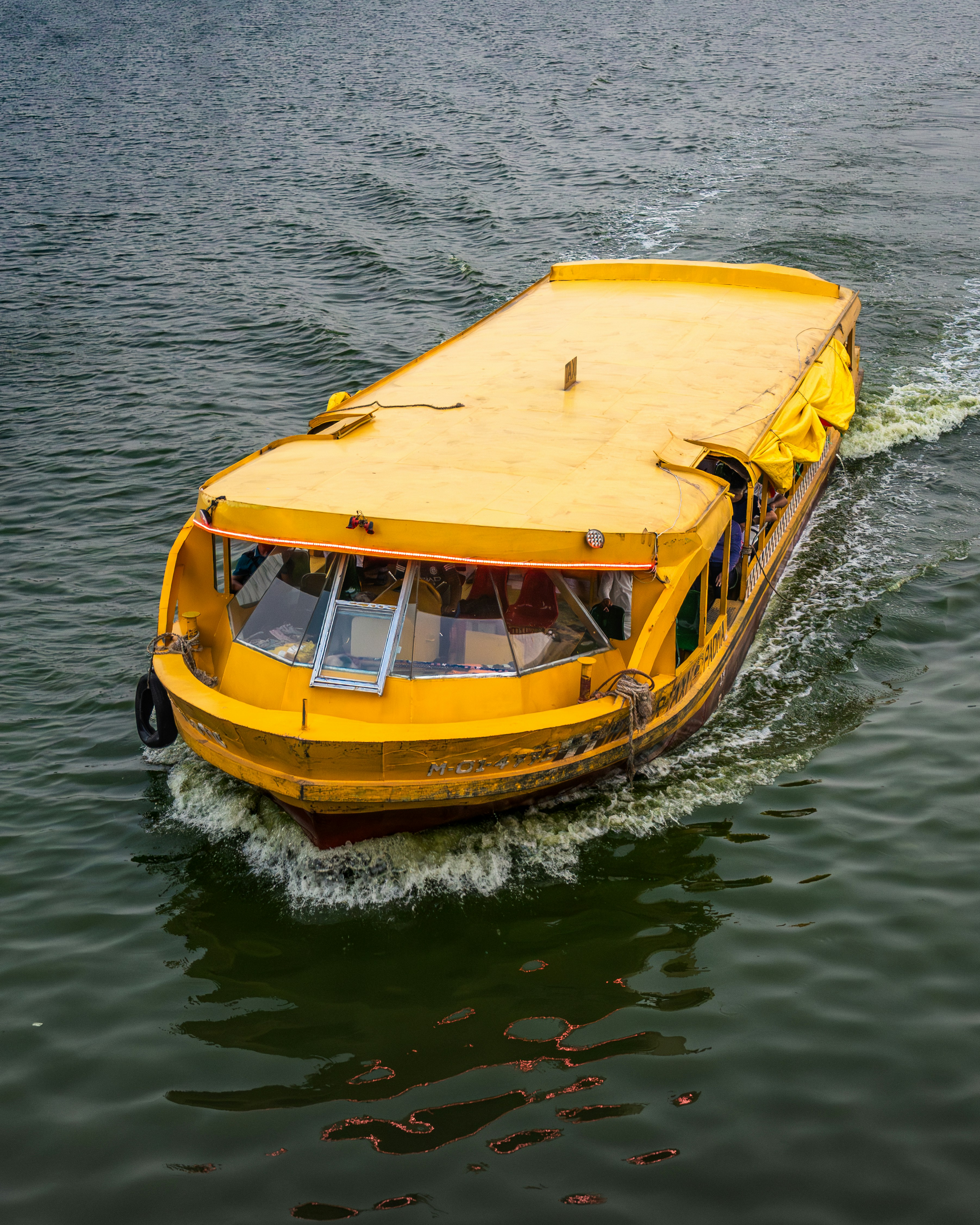 Golden Vessel Leading the Wake: Aerial View of a Bright Yellow Boat