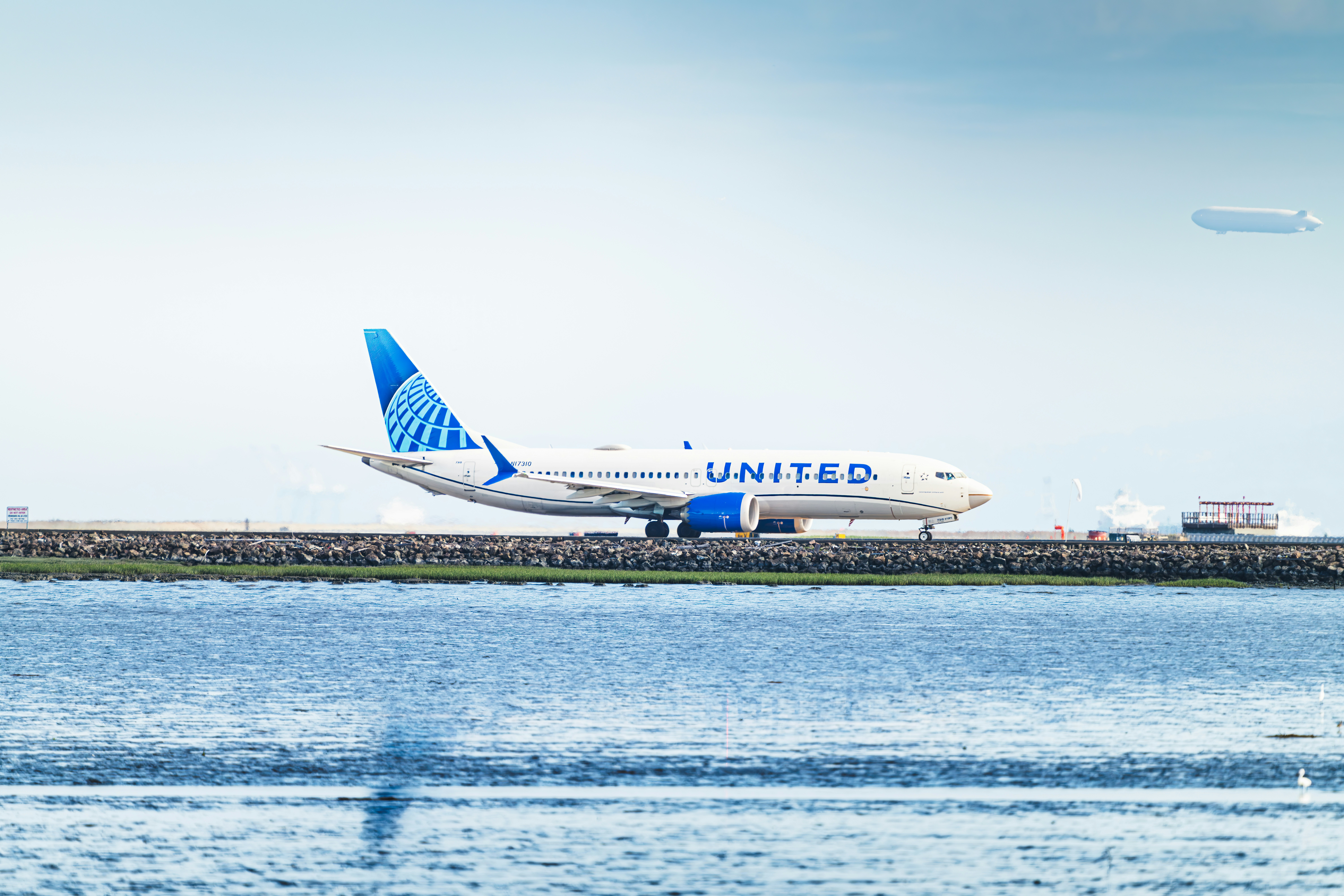 United in Flight: A calm ocean backdrop frames a United jumbo ready for takeoff