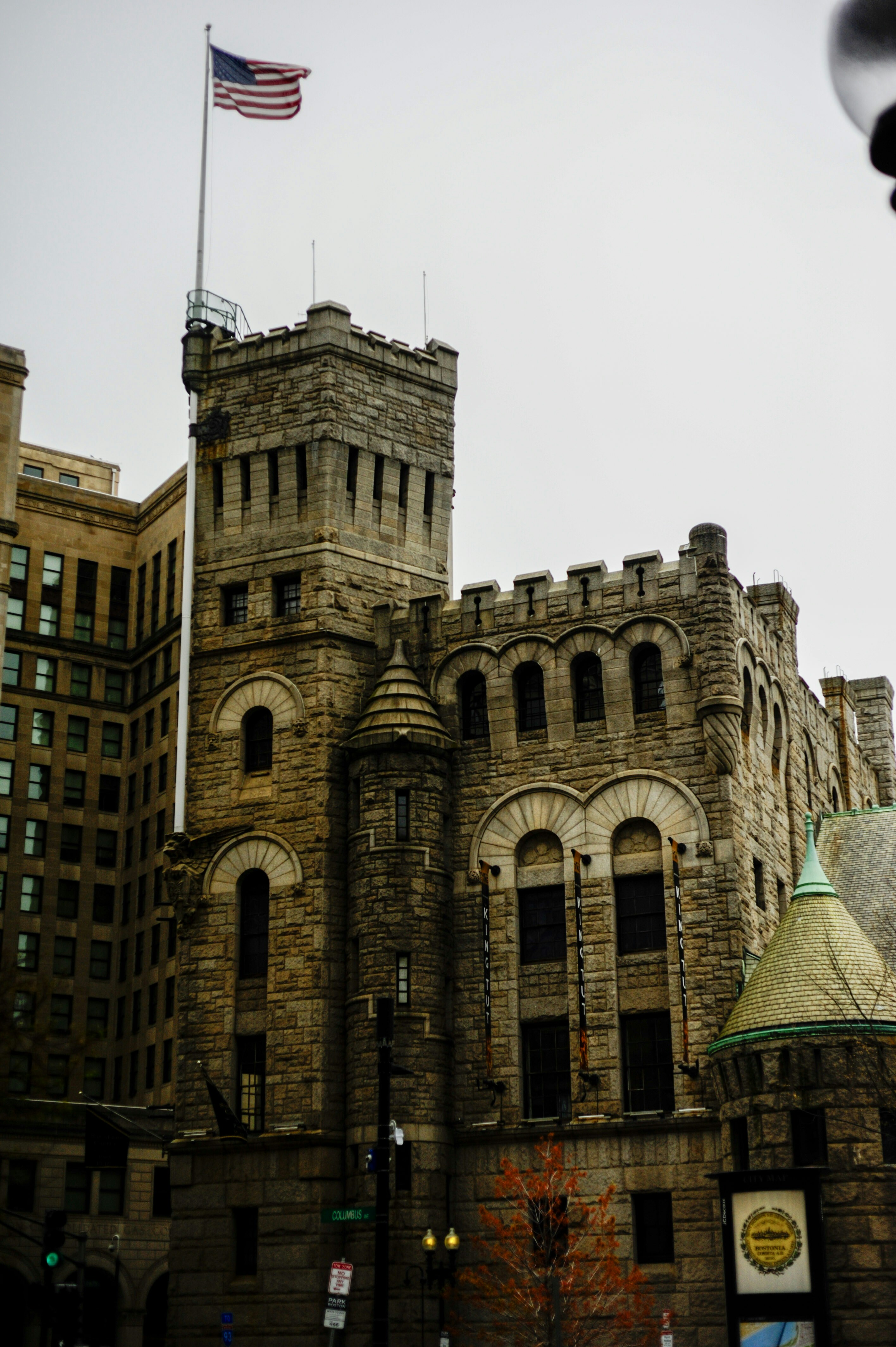 Flag over Fortress: A Historic Facade Under Urban Sky