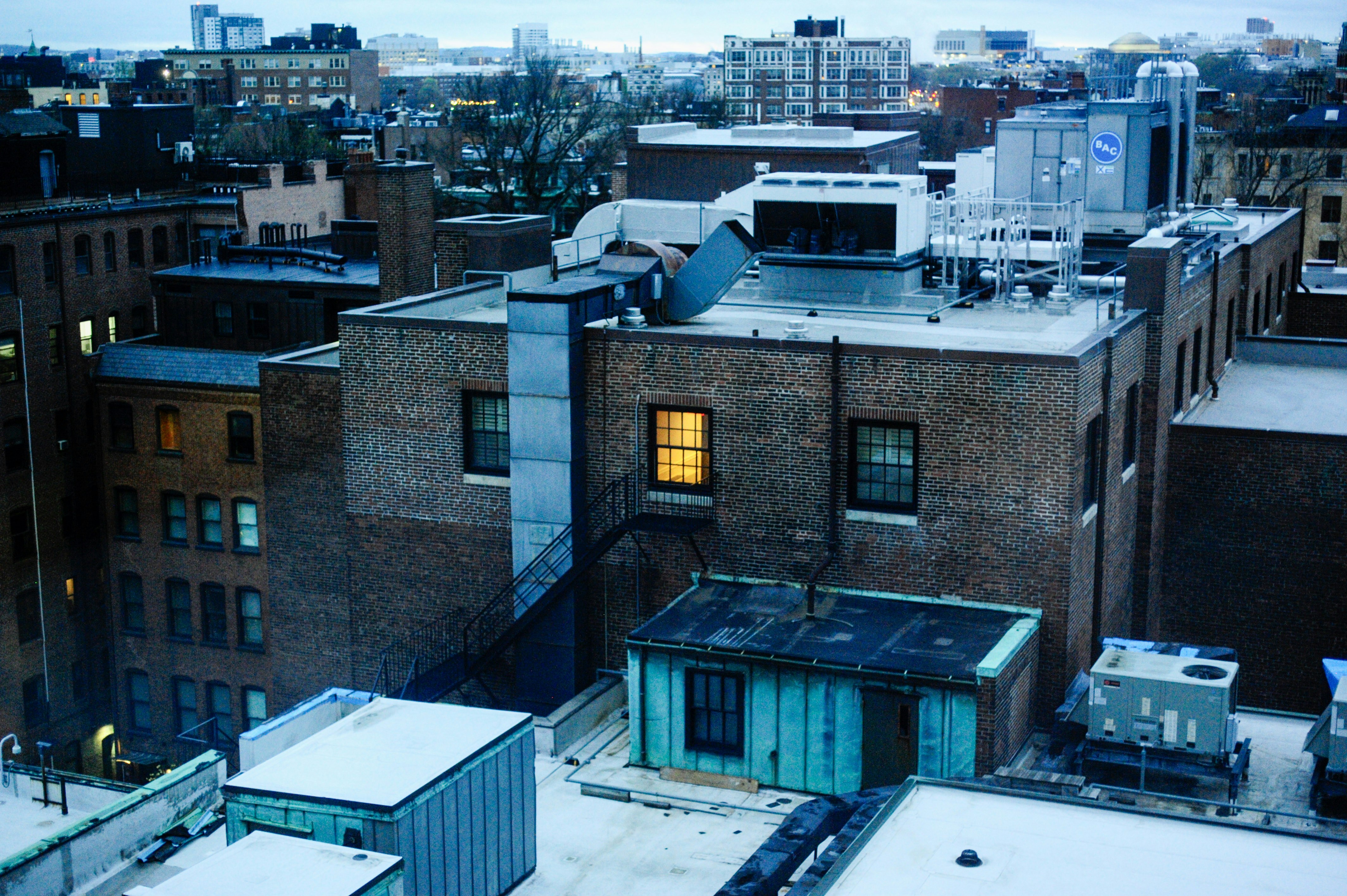 Warm Window Light Amid Rainy Rooftop Mosaic