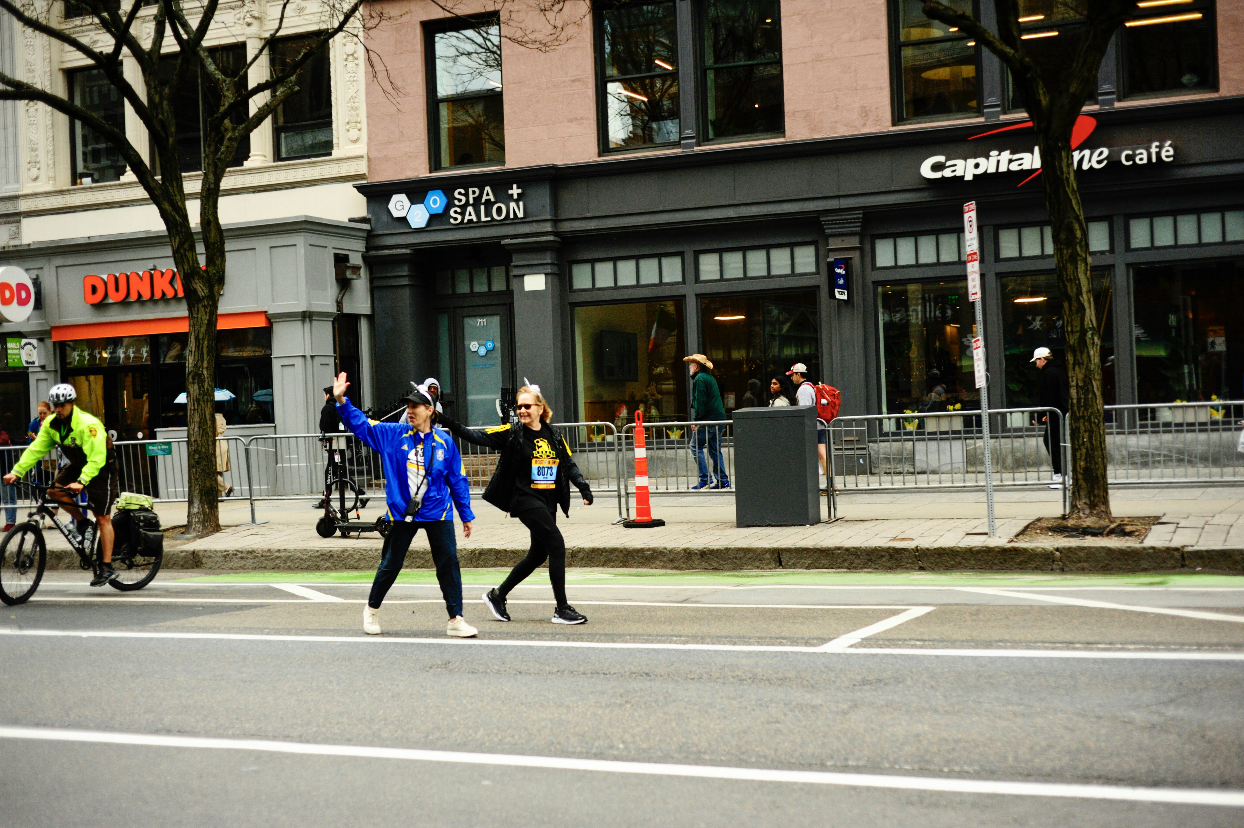 Two runners share a triumphant stride past a city block