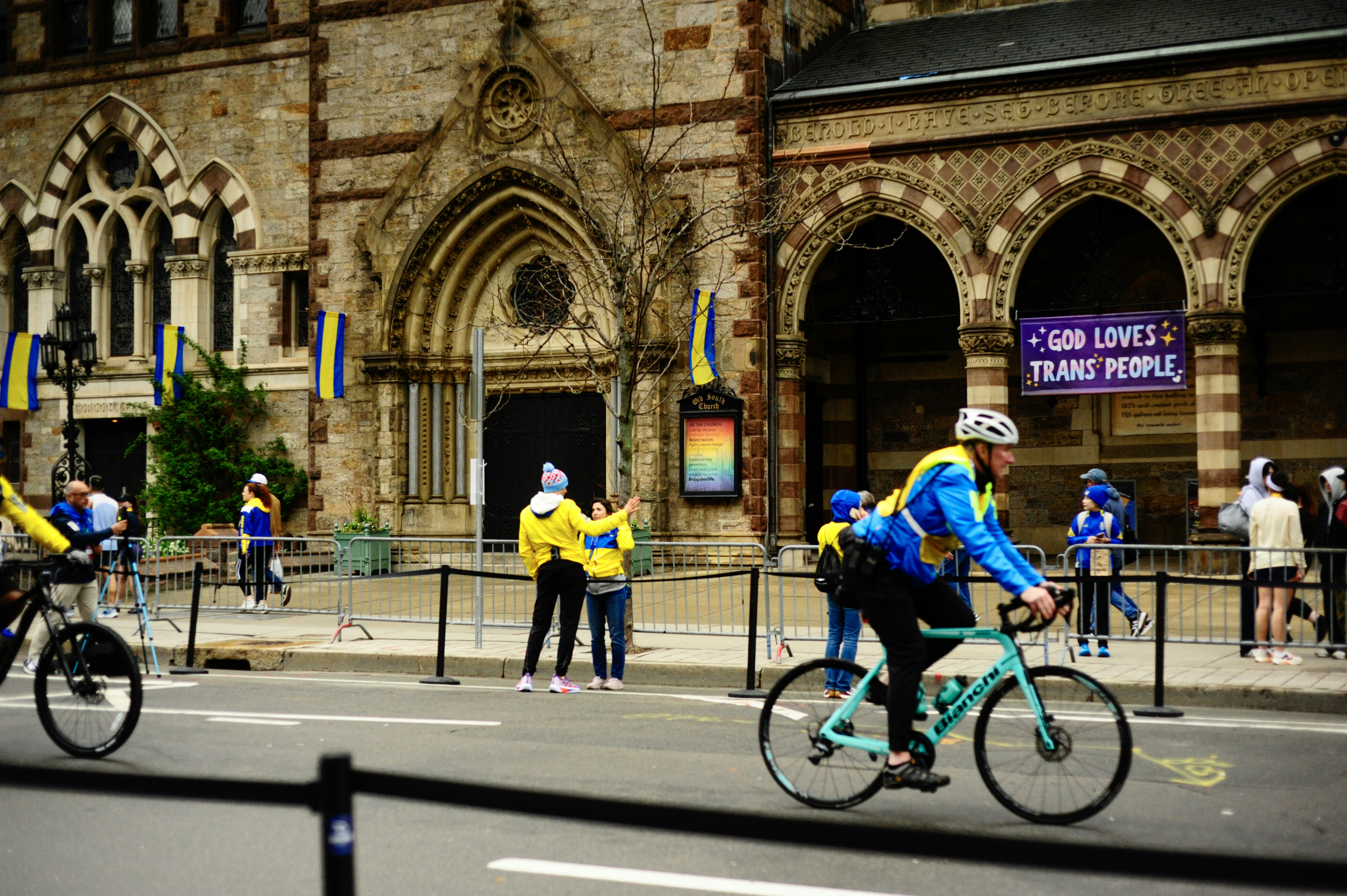 Blue-Jacket Cyclist in Front of Historic Facade