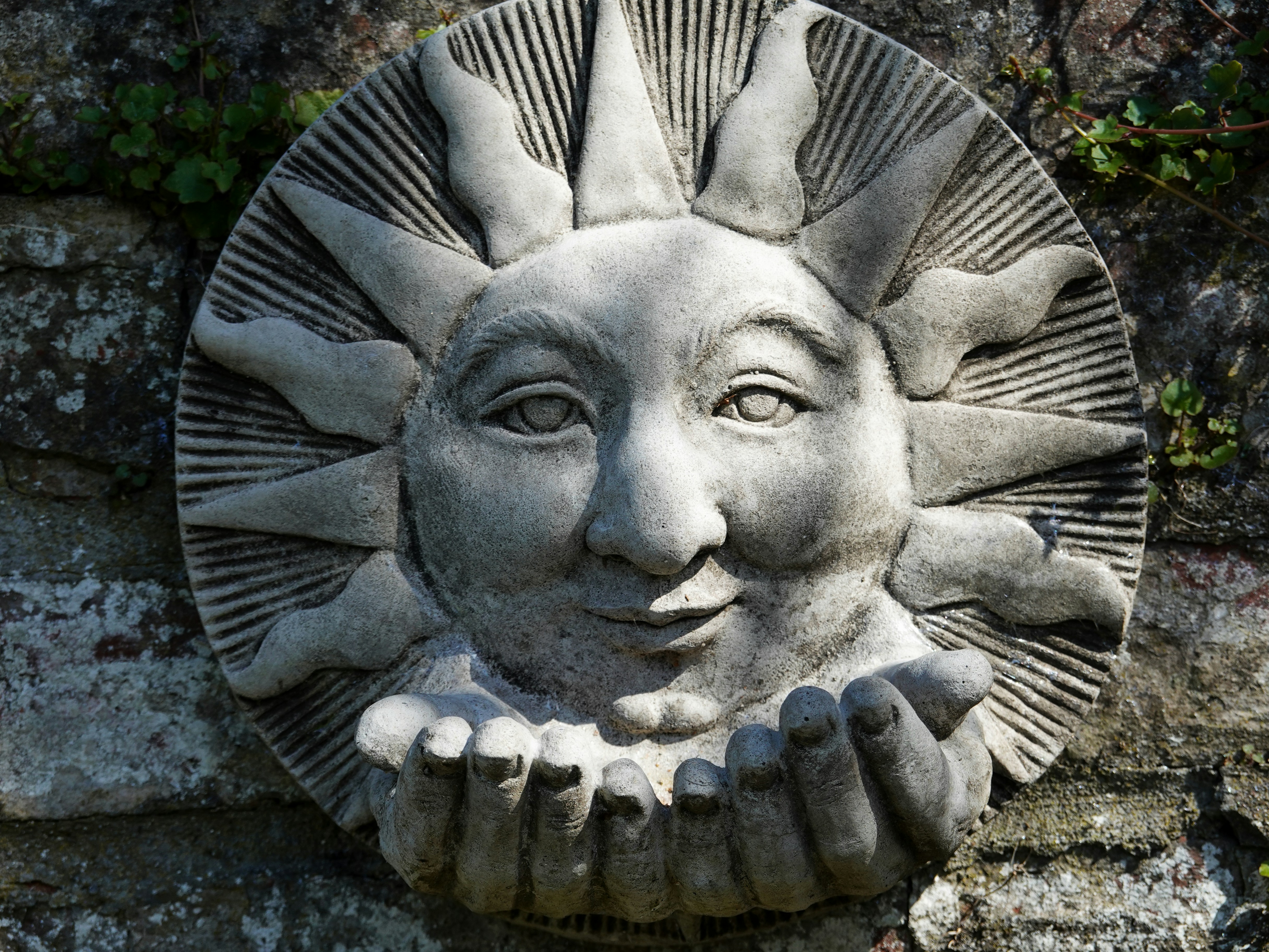 Stone Sun with Open Hands: A Gracious Face Emerging from the Wall