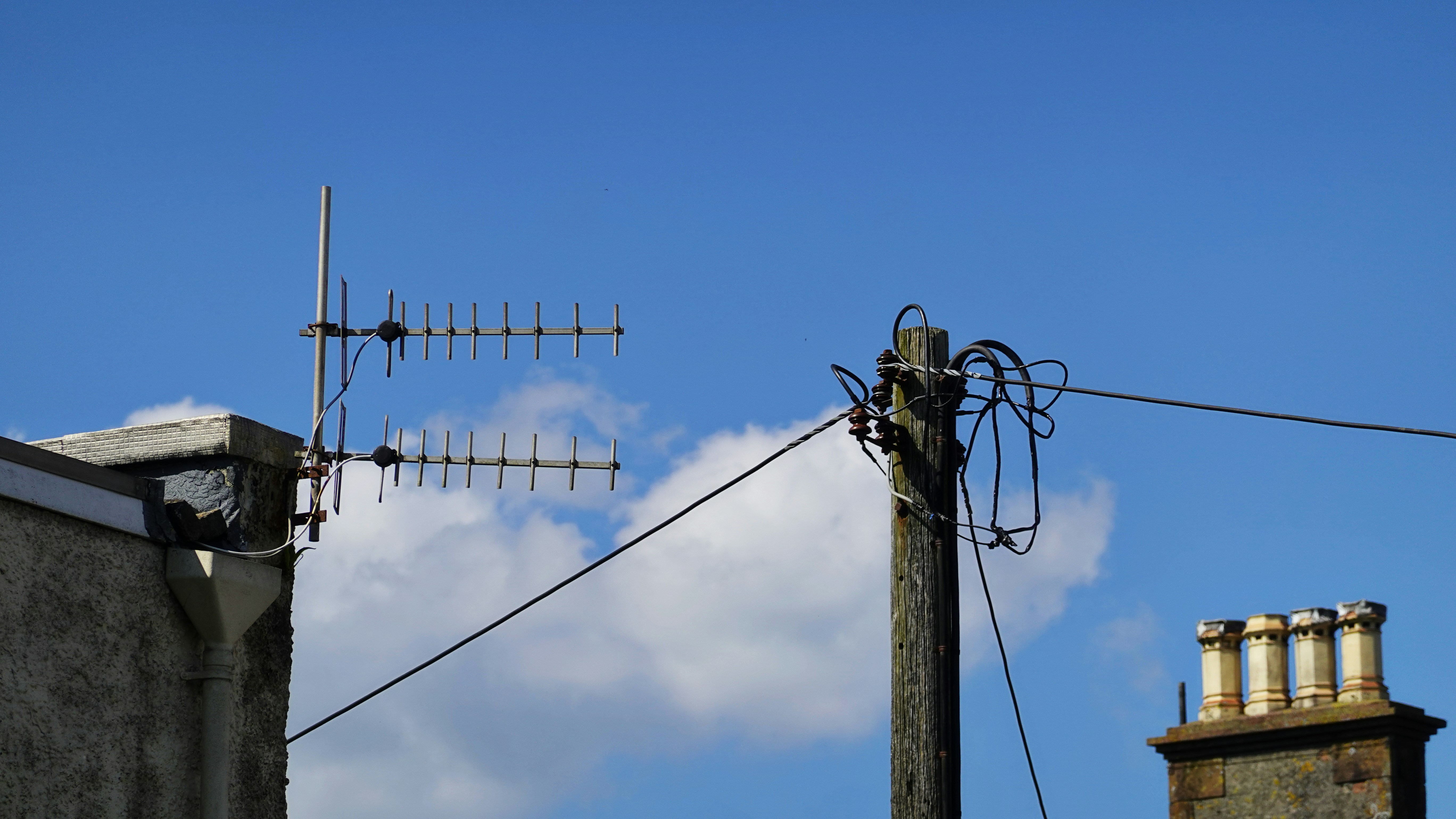 Wire and Weathered Poles under a Clear Blue Sky
