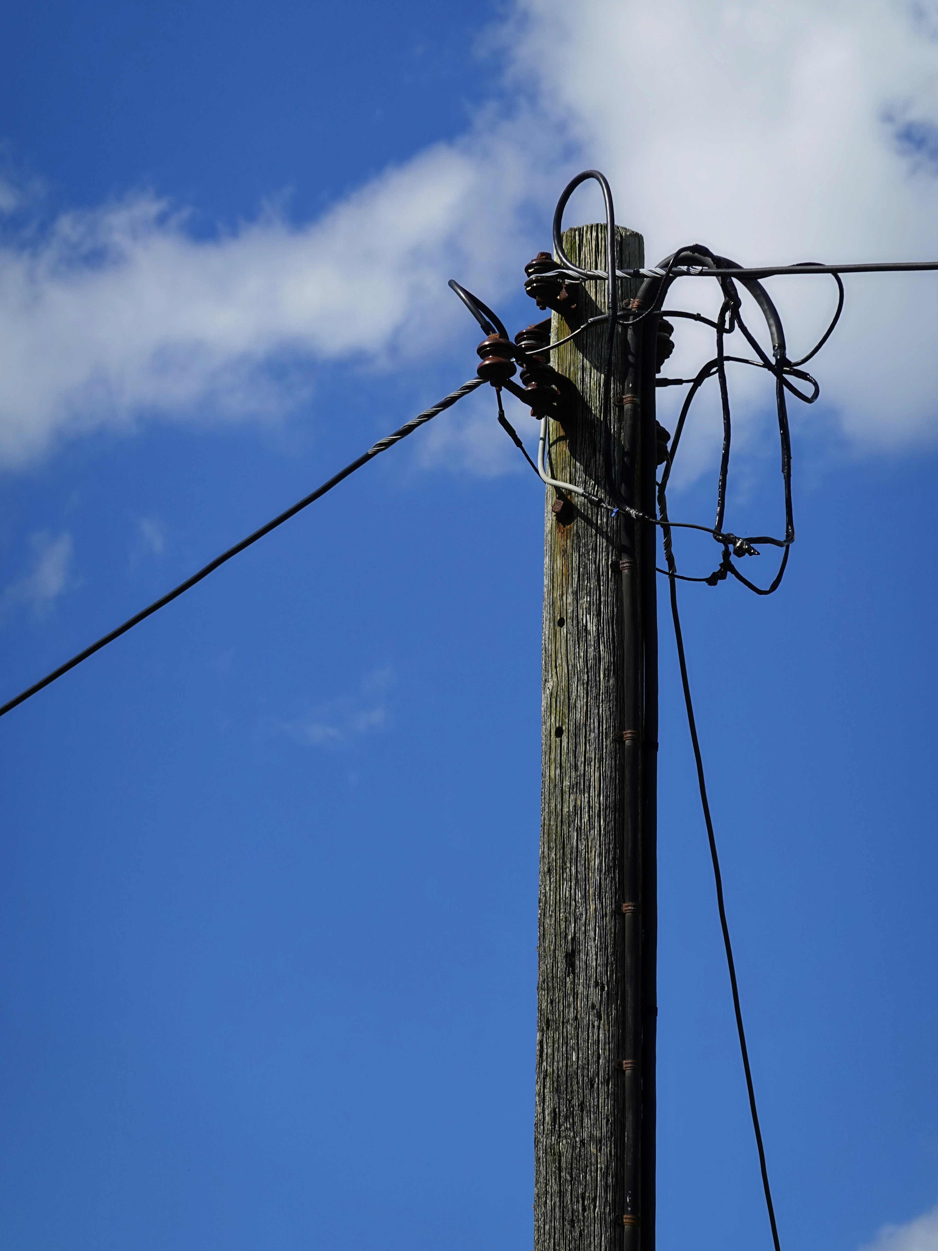Pole Topped with Weathered Cables under a Clear Blue Sky