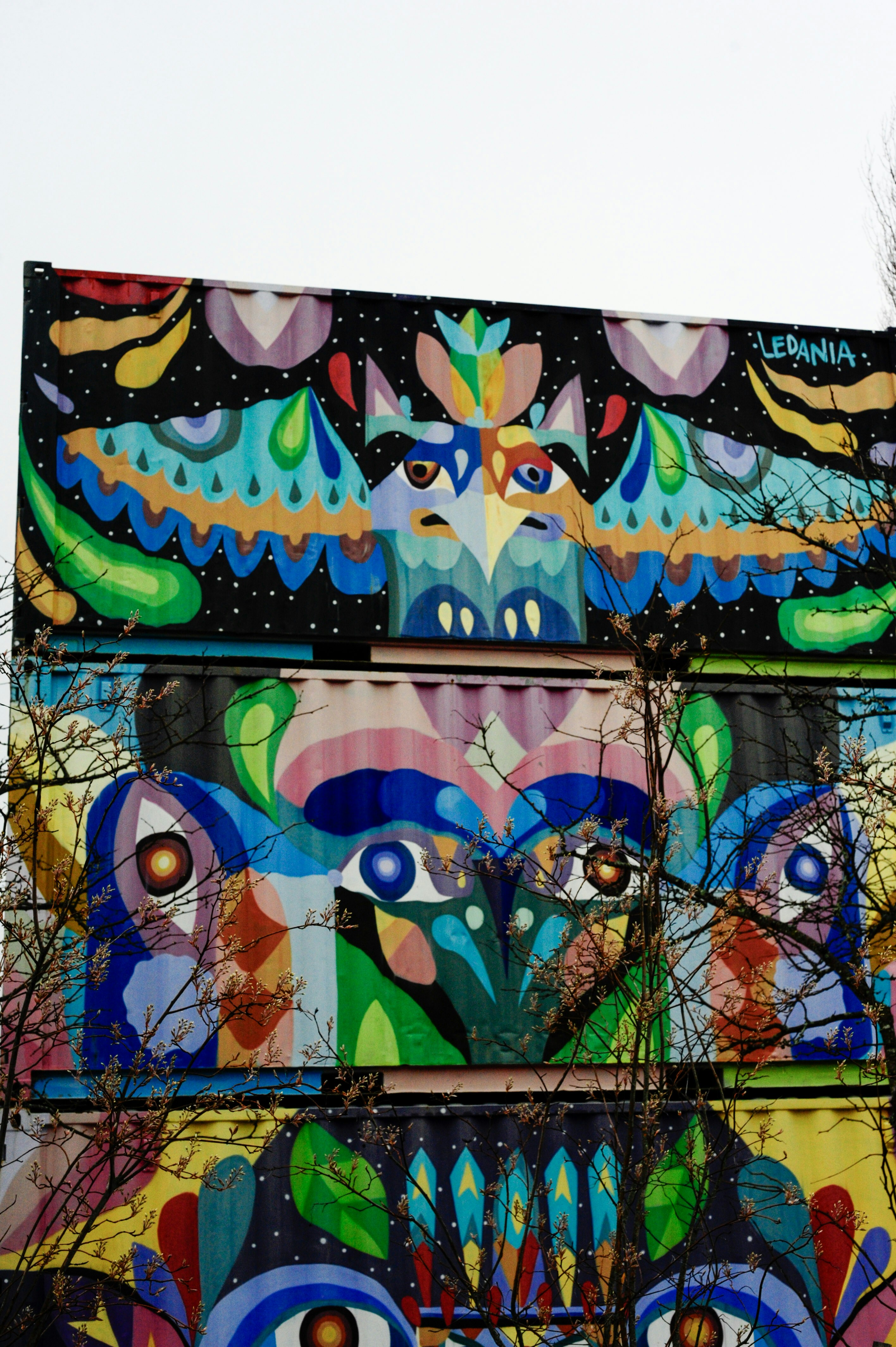 Chromatic Faces: A Tower of Murals Scaled by Winter Branches