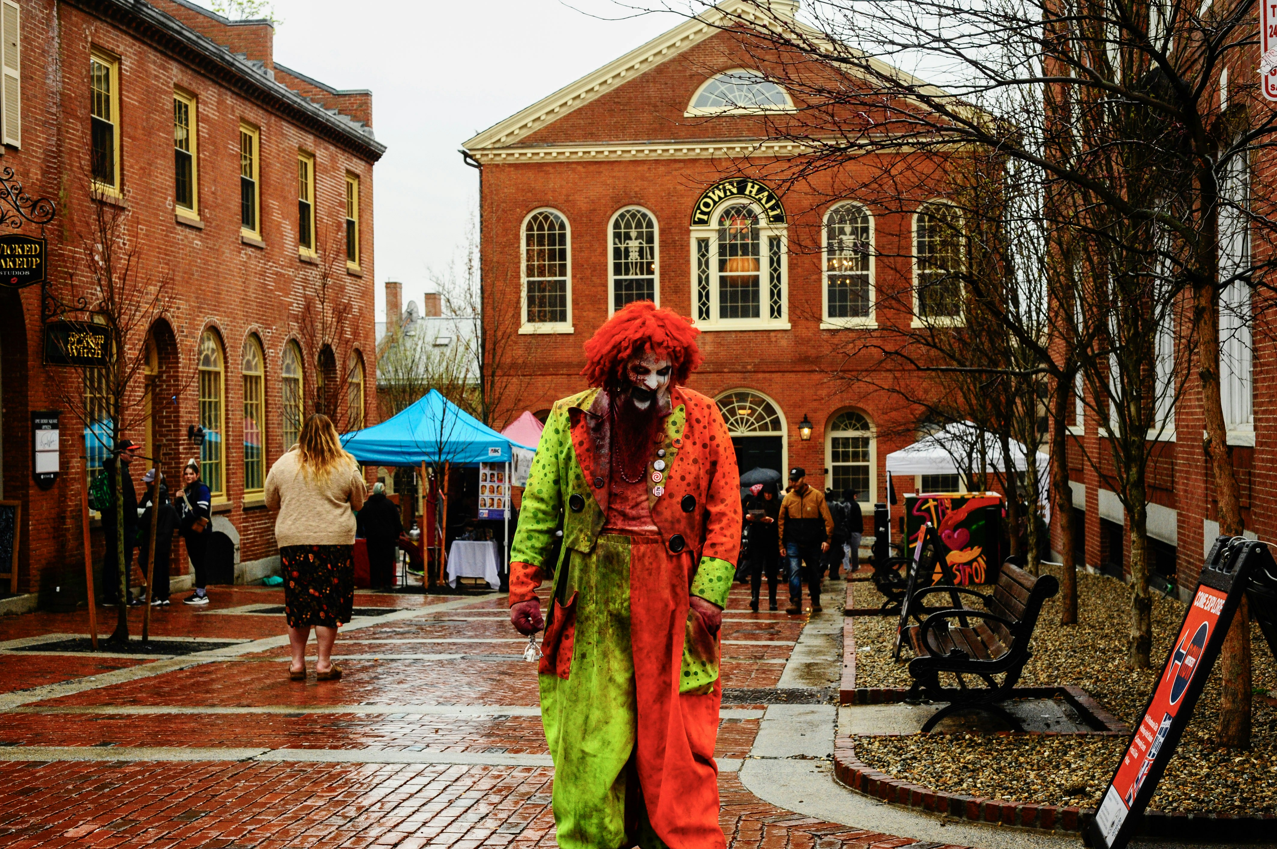 Vivid Clown in a Brick-Court Fair: A Street Scene of Color and Contrast