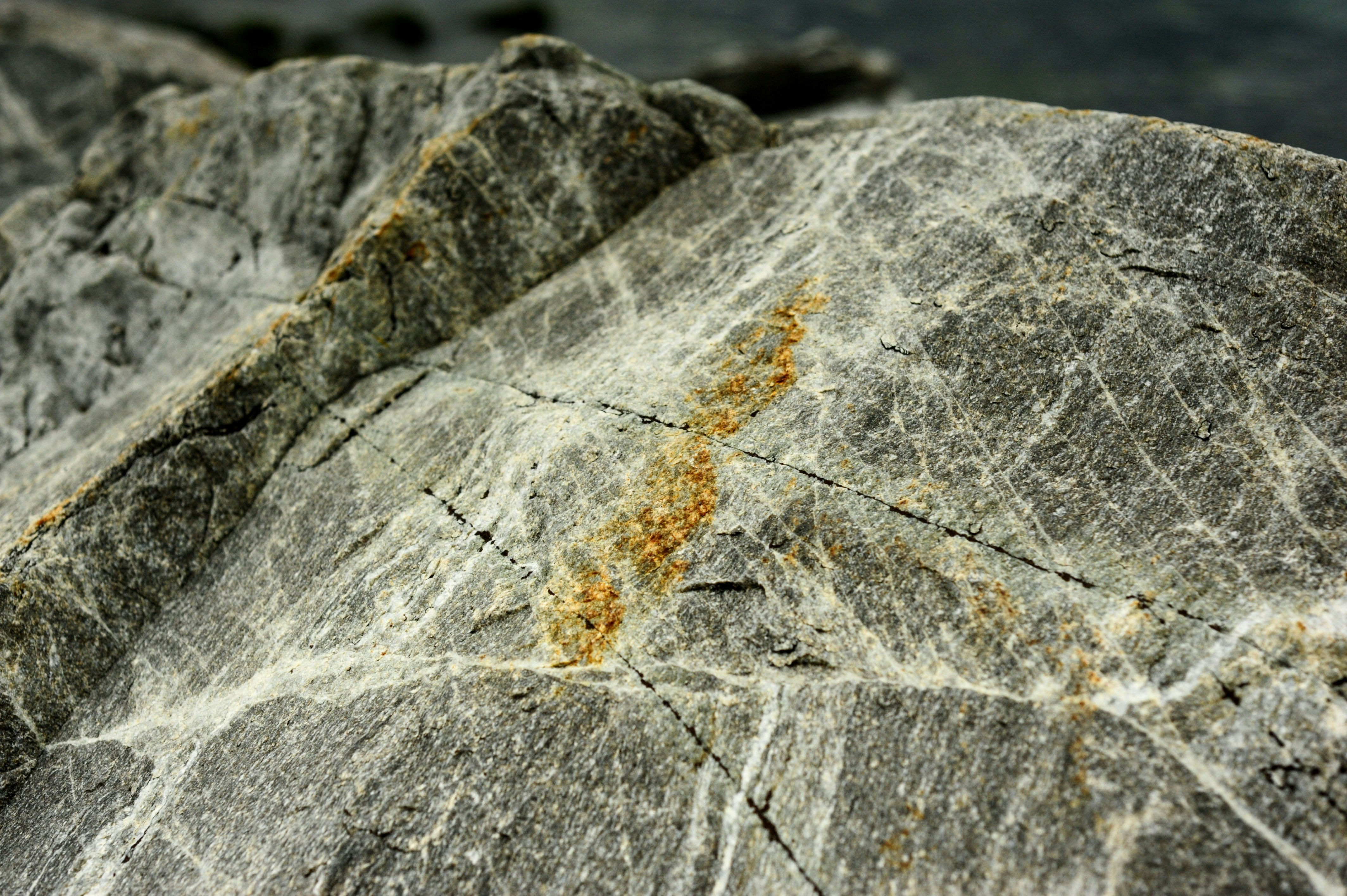 Weathered Granite Veins: A Close-Up of Rust Streaks on Rock