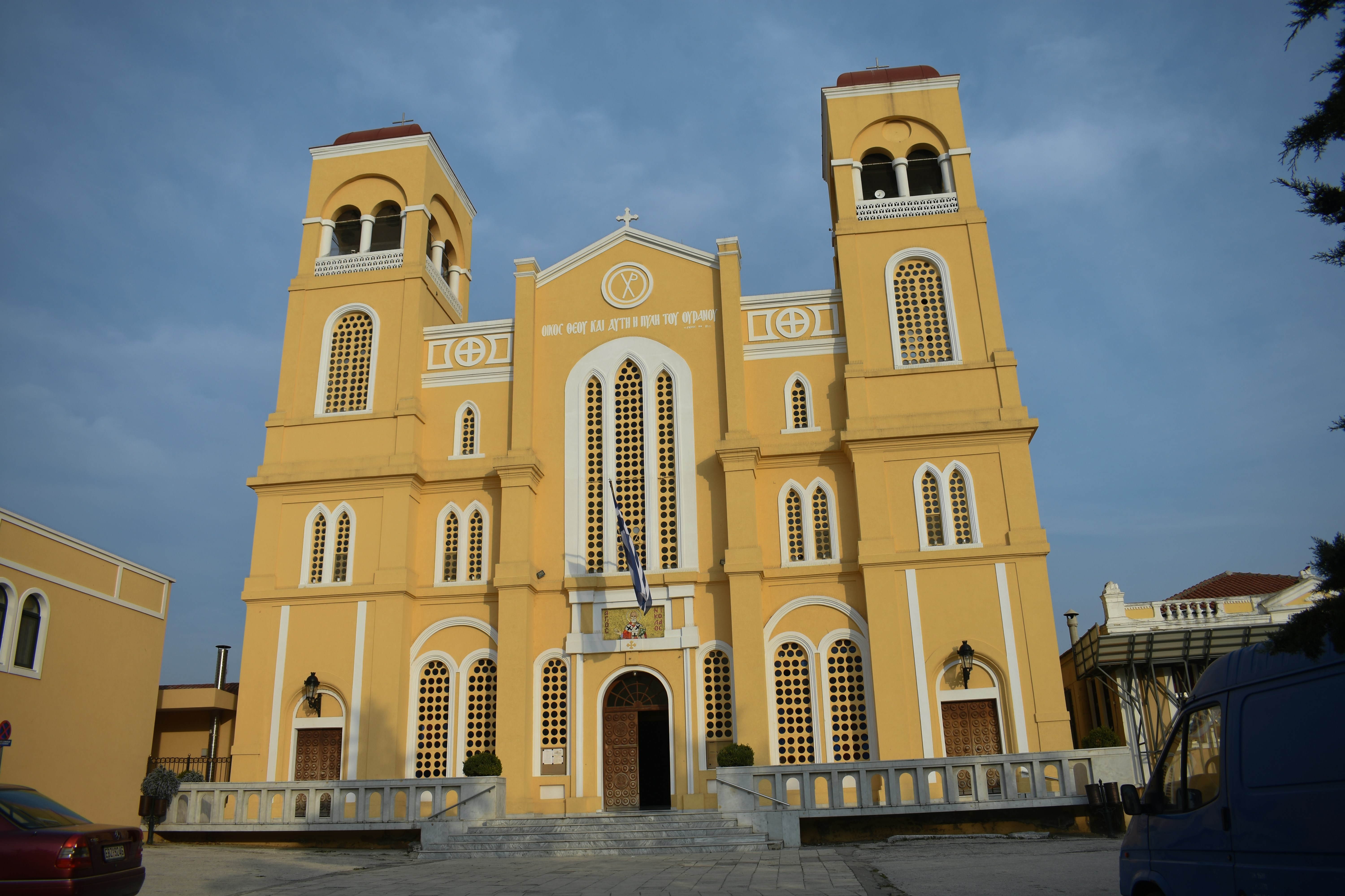 Sunny Facade of a Yellow Cathedral: Centered Towers and Grand Entrance