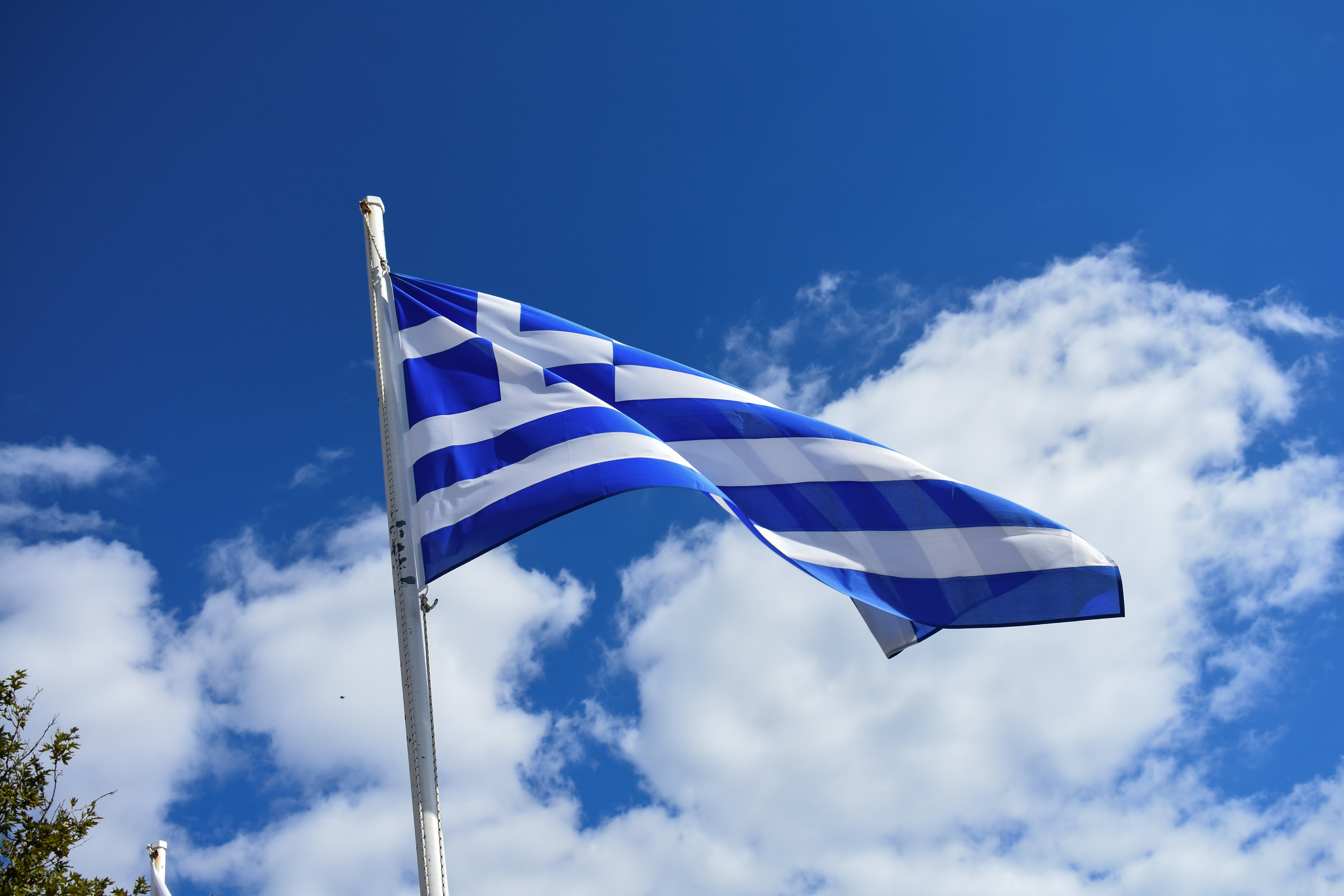 Flag of Greece Rippling Against a Bright Sky