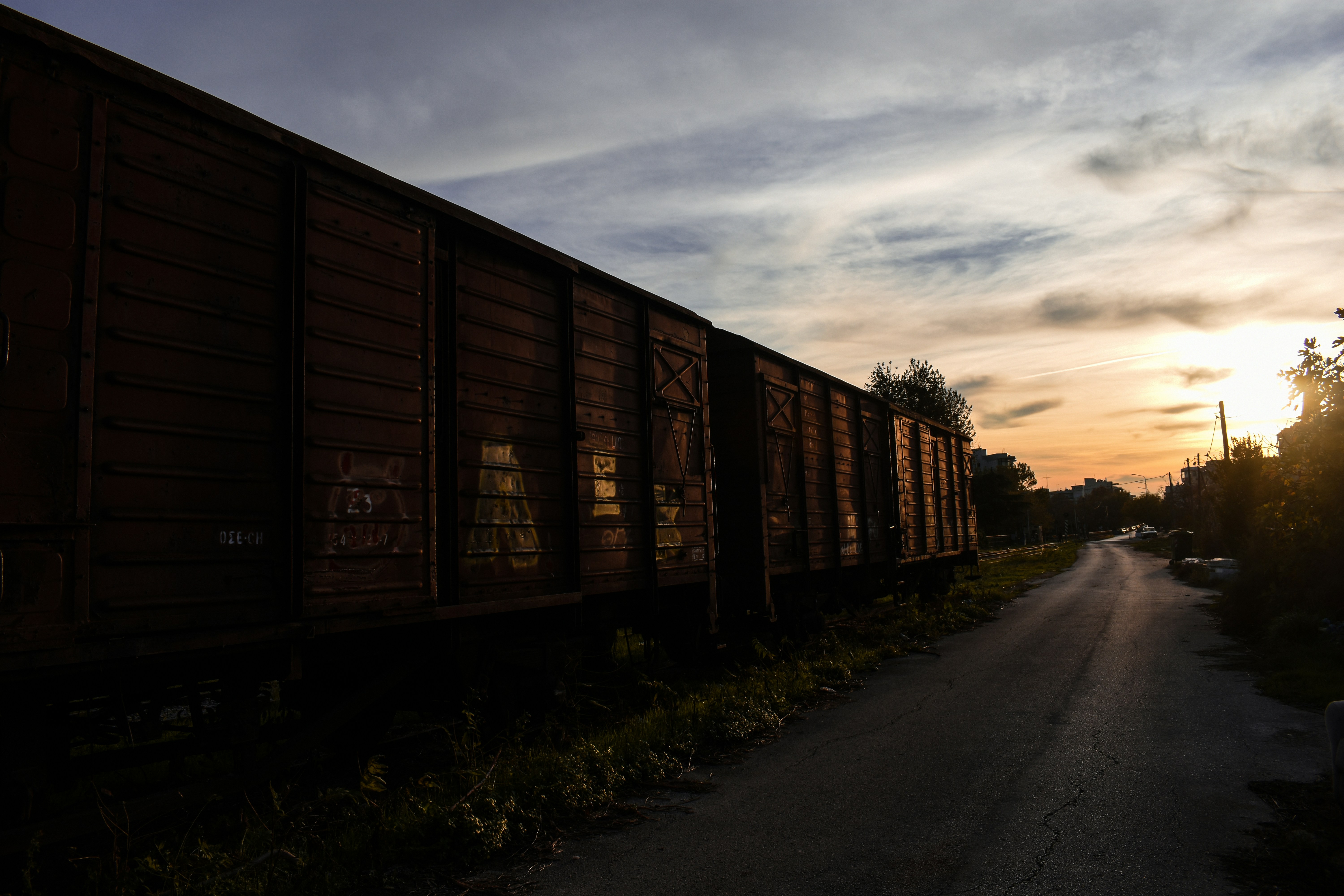 Sunset Freight: A Quiet Railroad Trail Bordered by Weathered Cars
