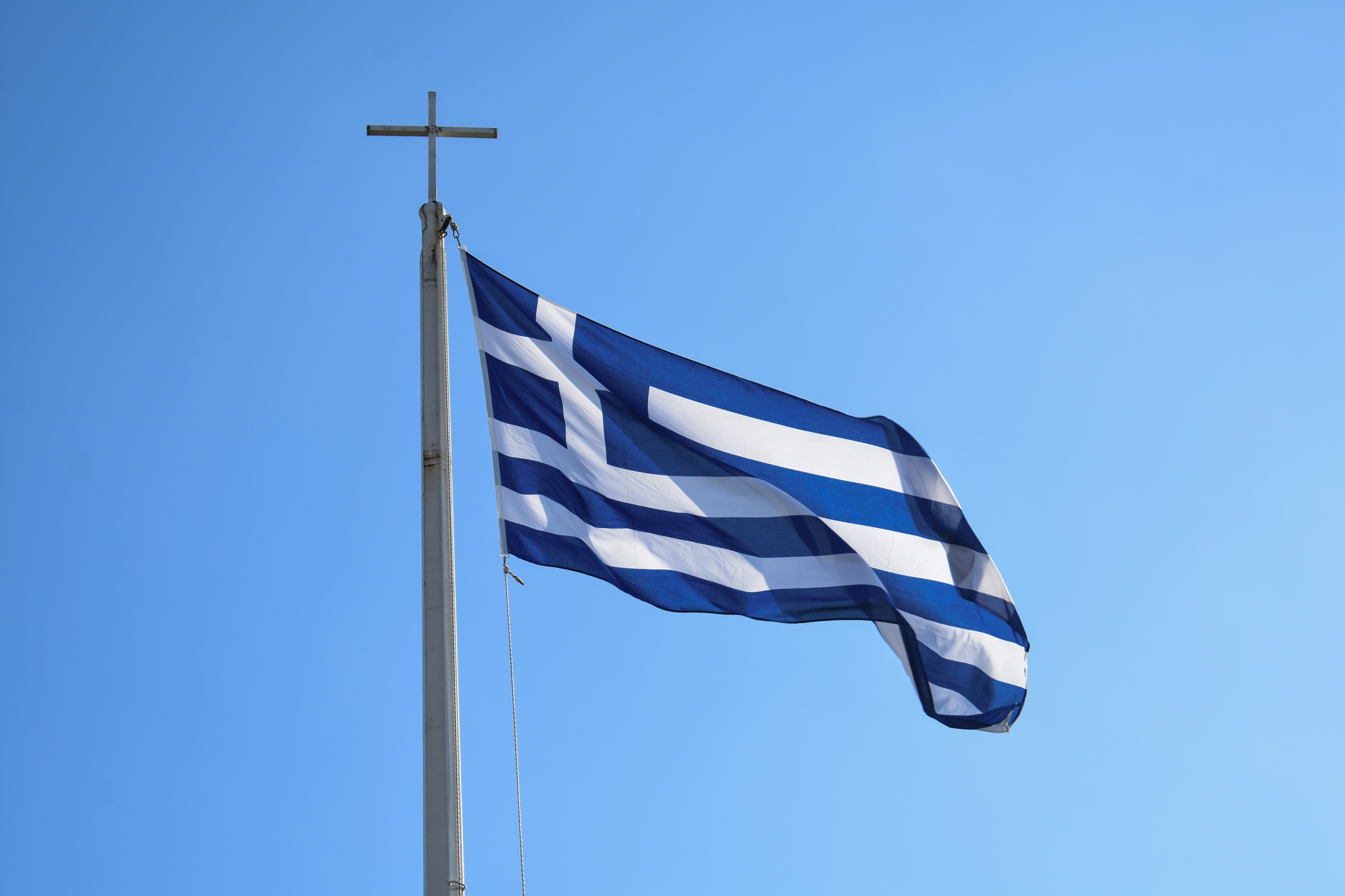 Flag Over a Clear Sky: Greek Tricolor in a Gentle Breeze