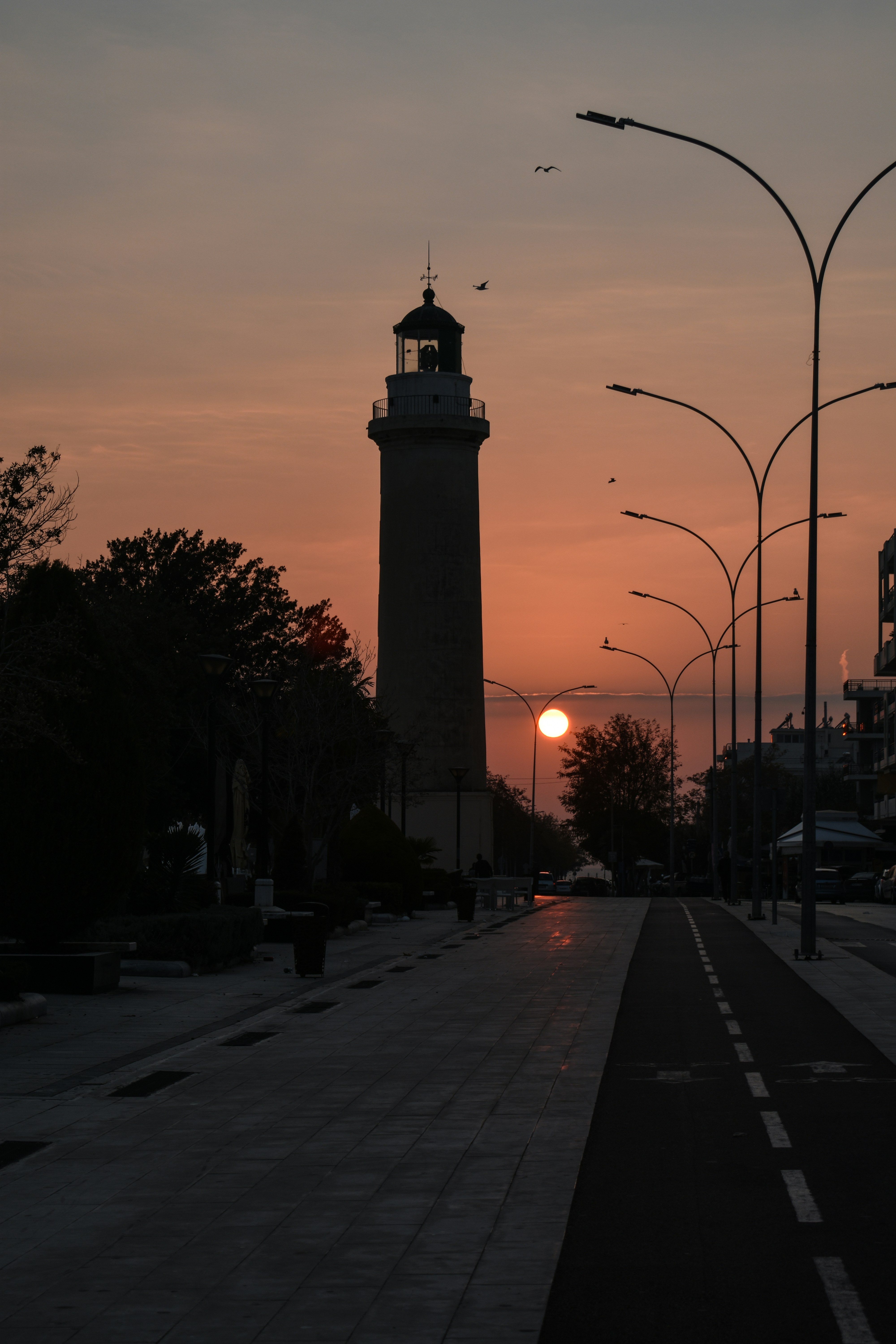 Sunset Sentinel: A Lantern-Lined Promenade Embracing the Lighthouse
