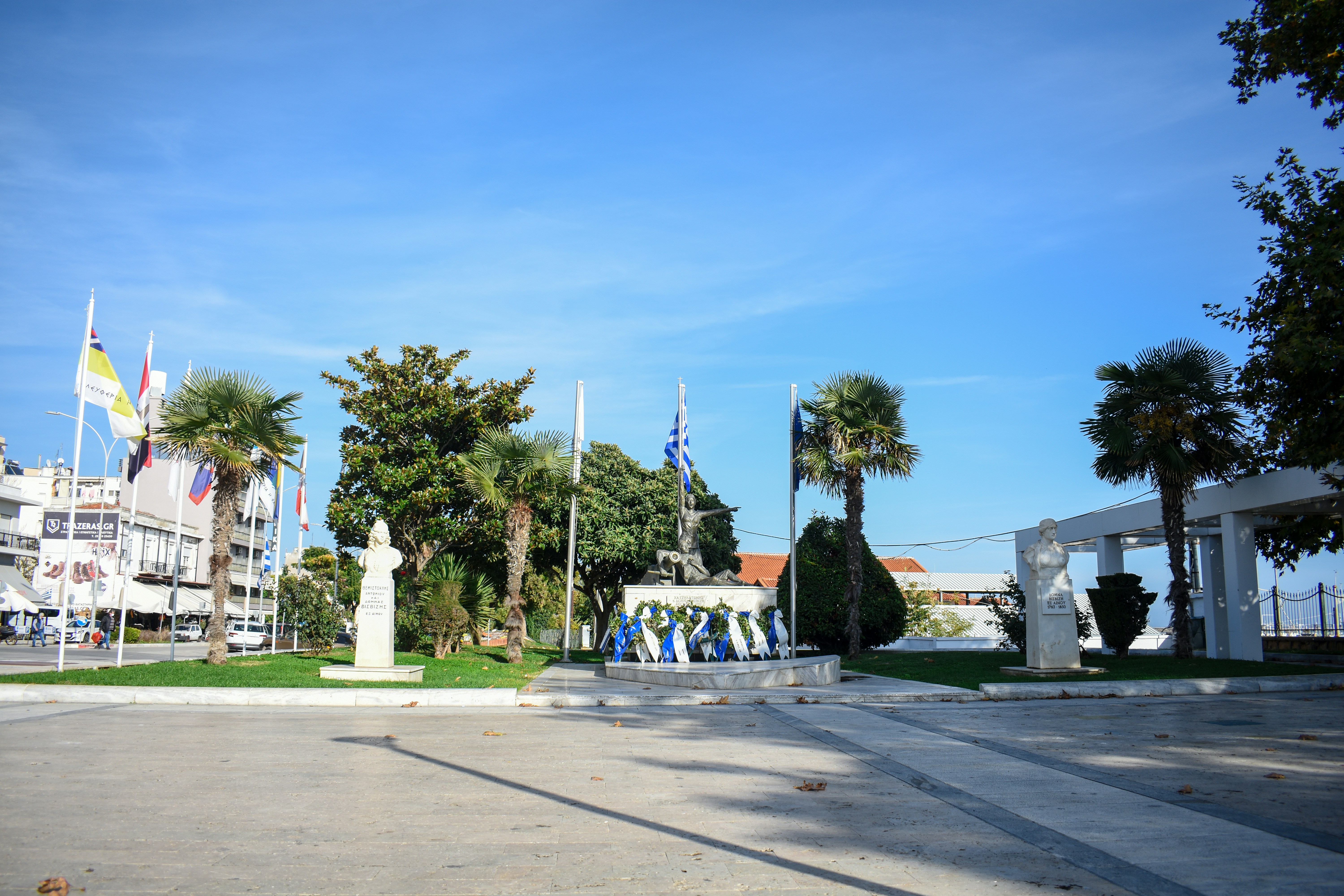 Flag-lined Plaza with Central Monument under a Clear Sky