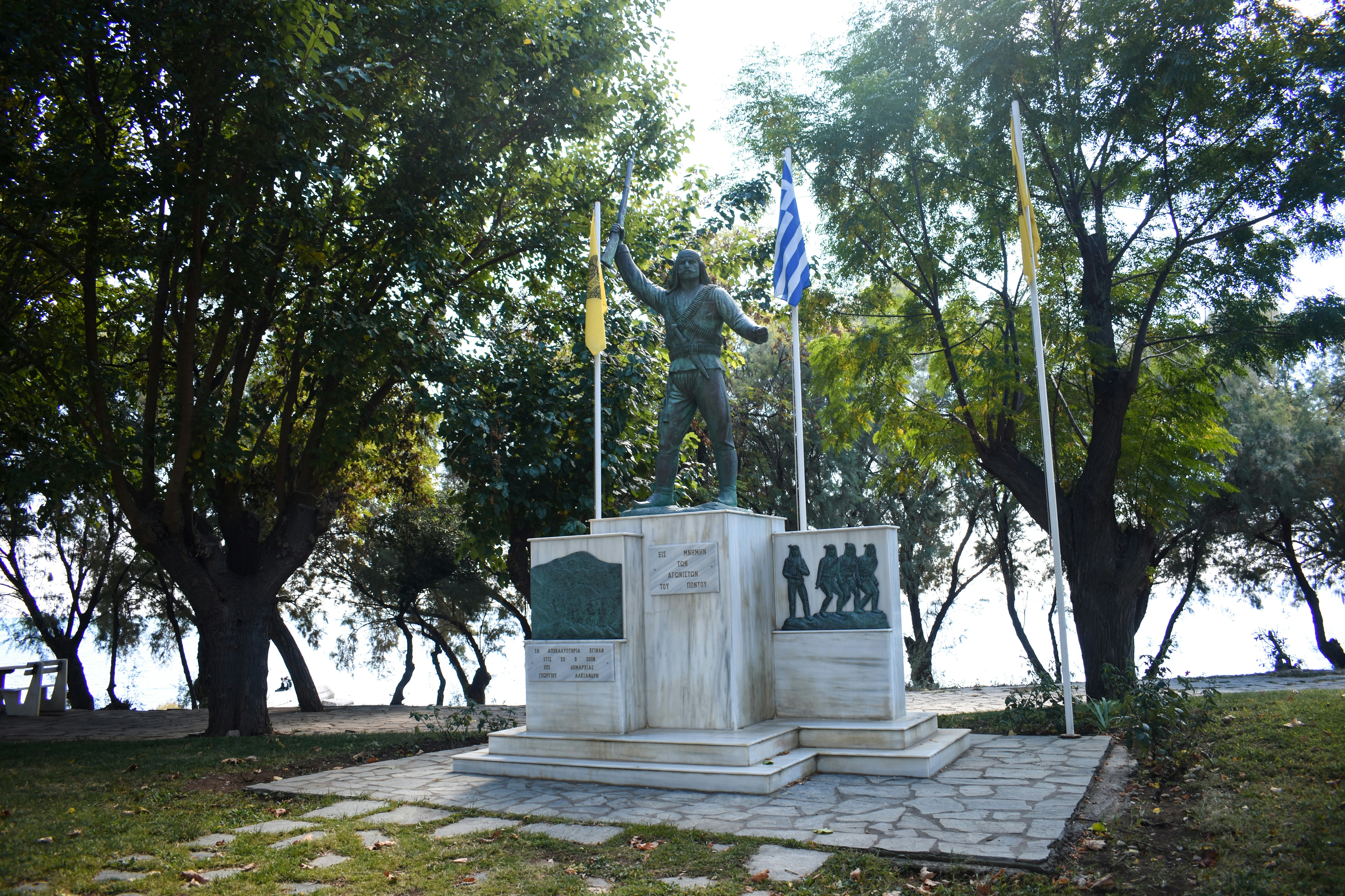 Statue on Stone Pedestal Framed by Tree Canopy
