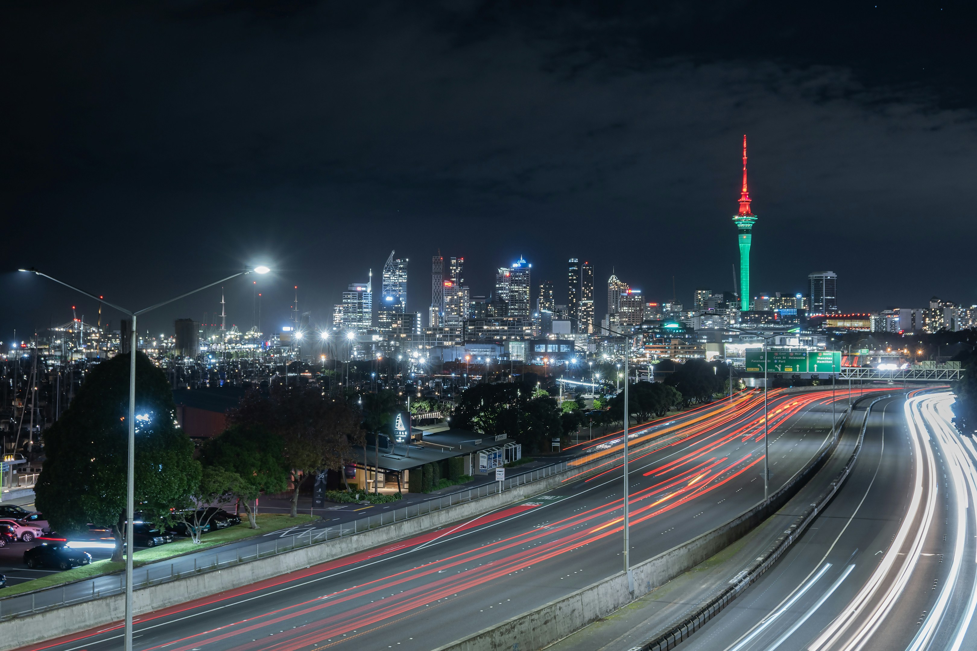 Night City Flow: Trails of Light Over a Crowned Skyline