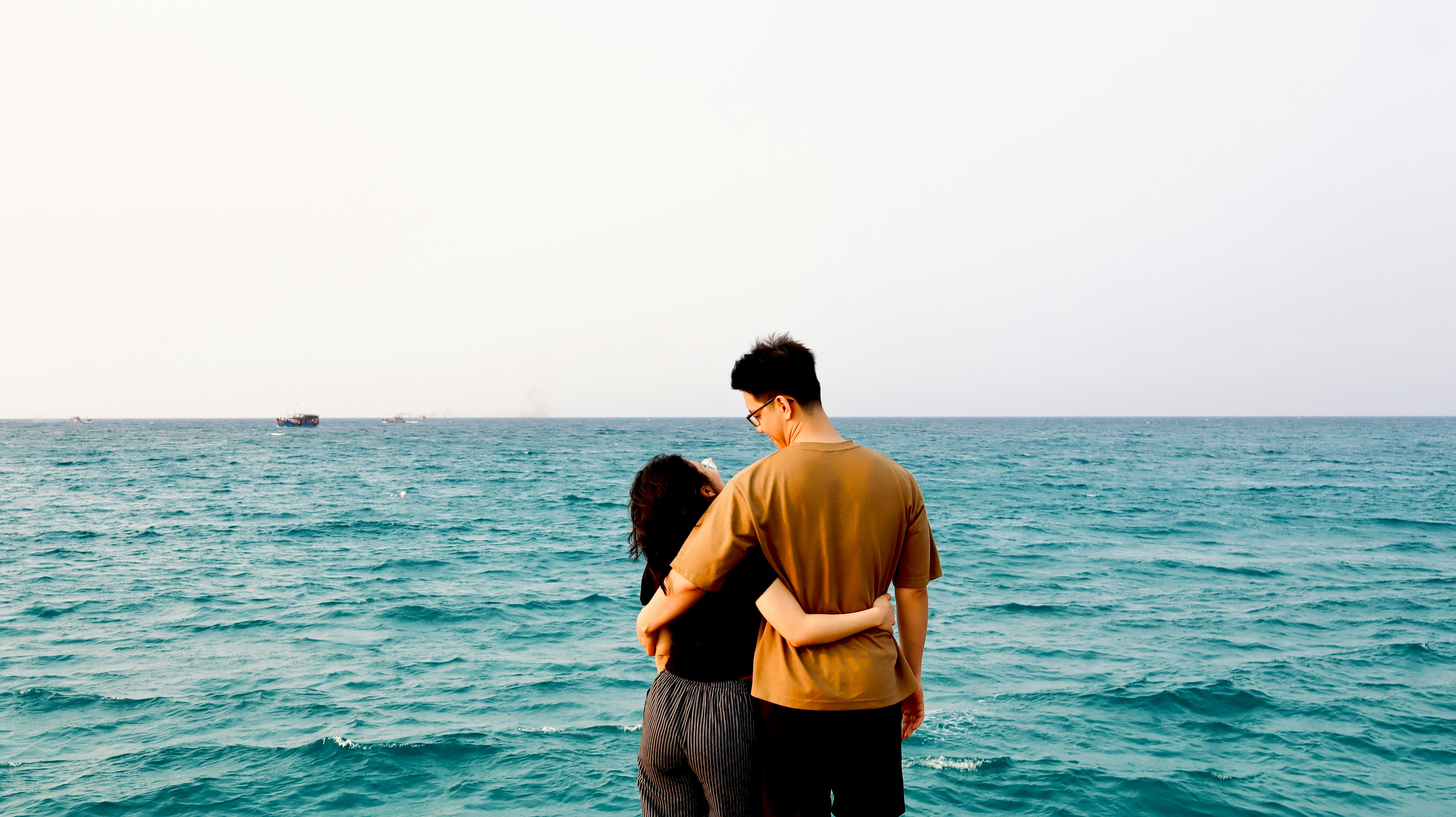 Embrace by the Sea: Two silhouettes in a quiet horizon