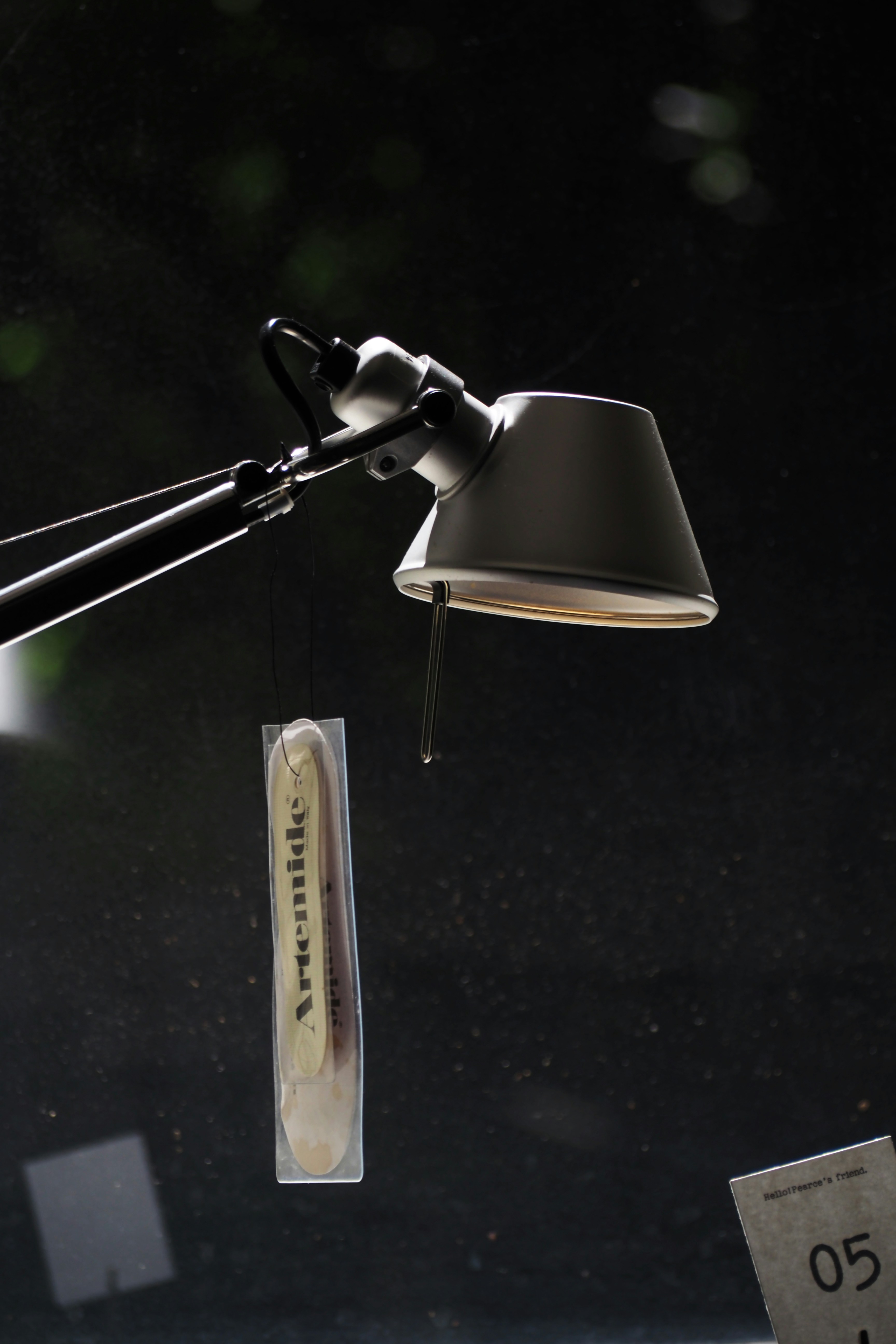 Focused Glow: A Desk Lamp Hovering Over a Suspended Branding Tag
