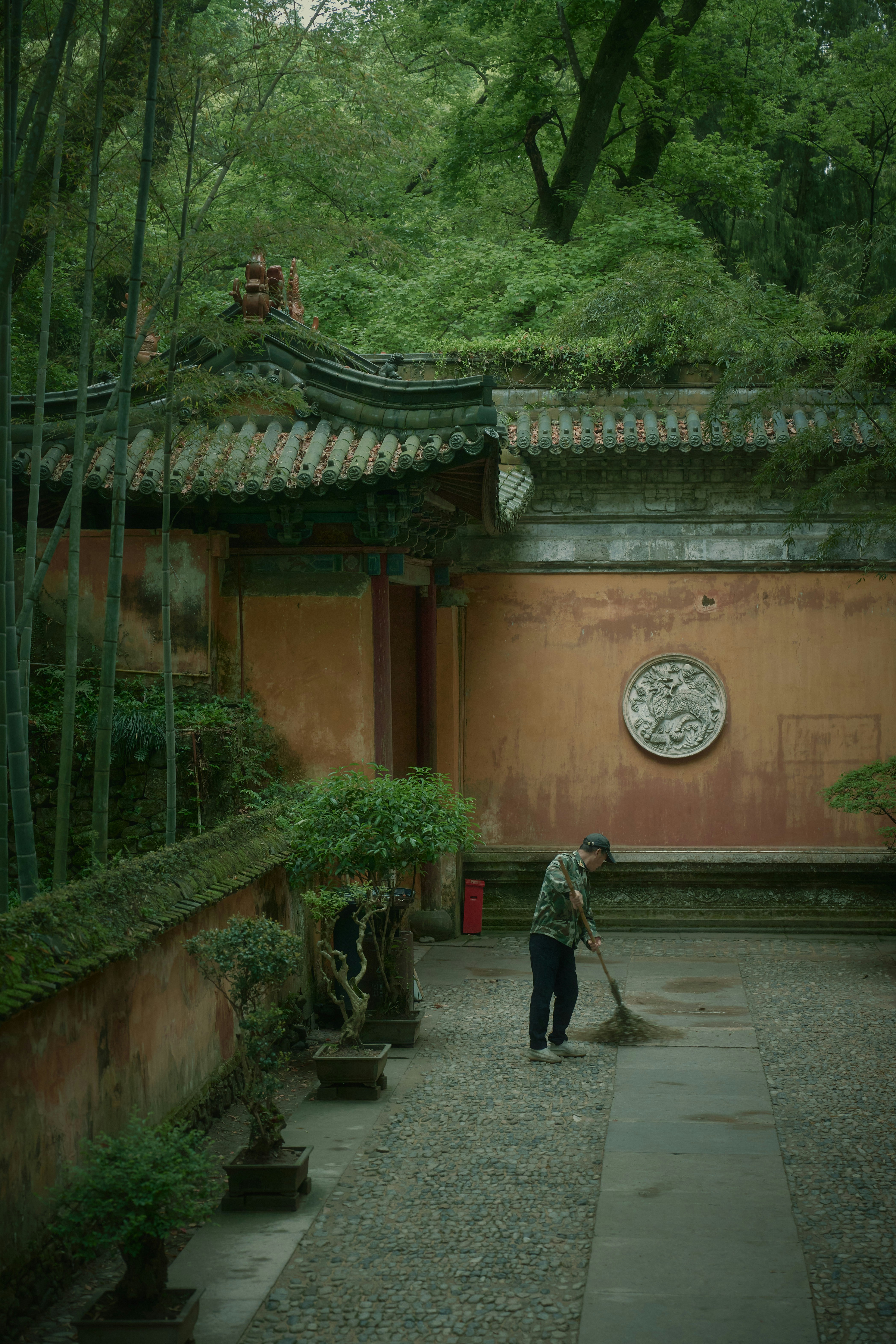 Silent Courtyard Sweep: A Caretaker Tends the Garden Wall