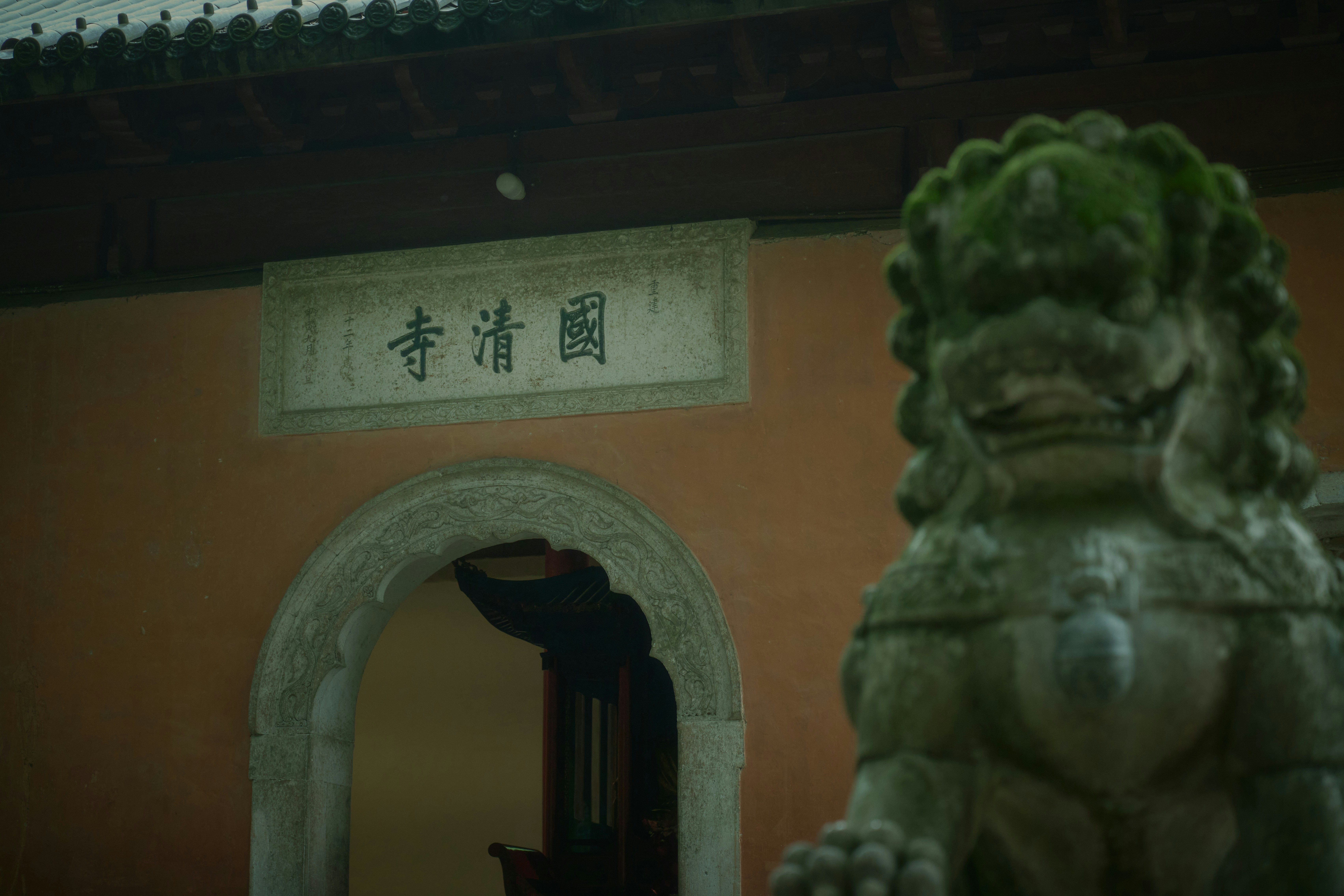  guardian at the gate: a temple lion shadows the doorway