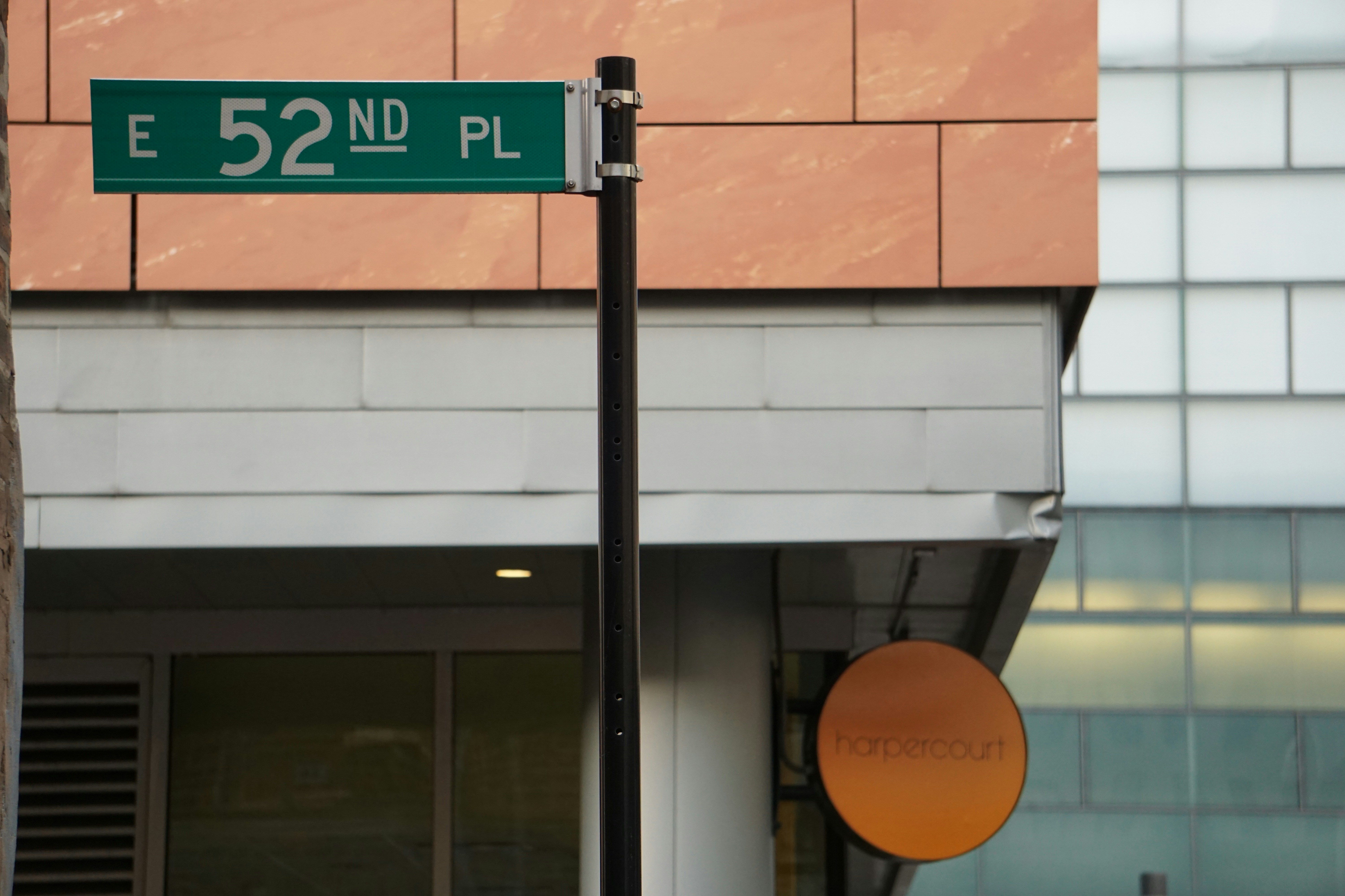 Urban Corner: The Green Street Sign Anchored by a Softly Lit Portal