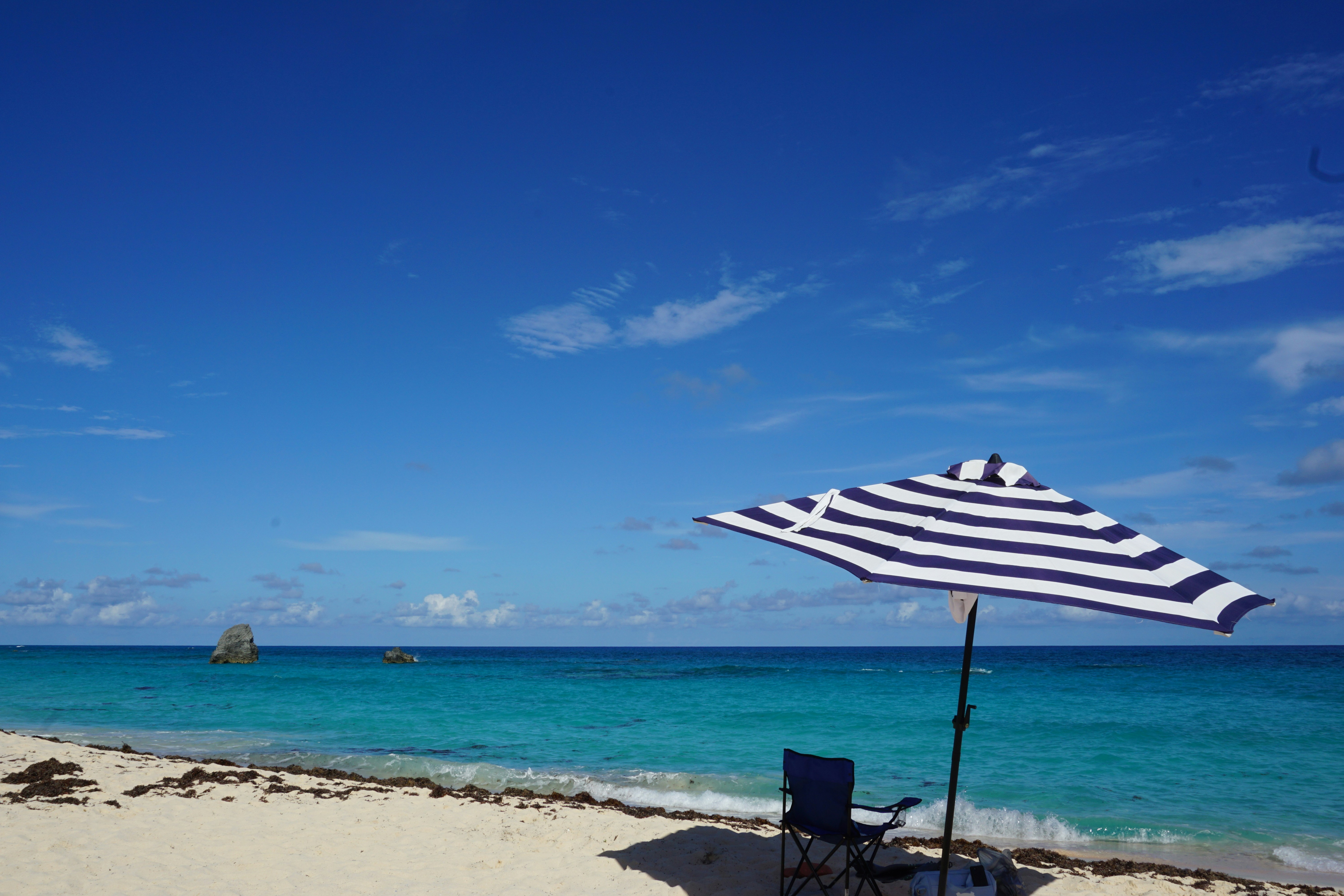 Striped Beach Umbrella at the Edge of Turquoise Waters
