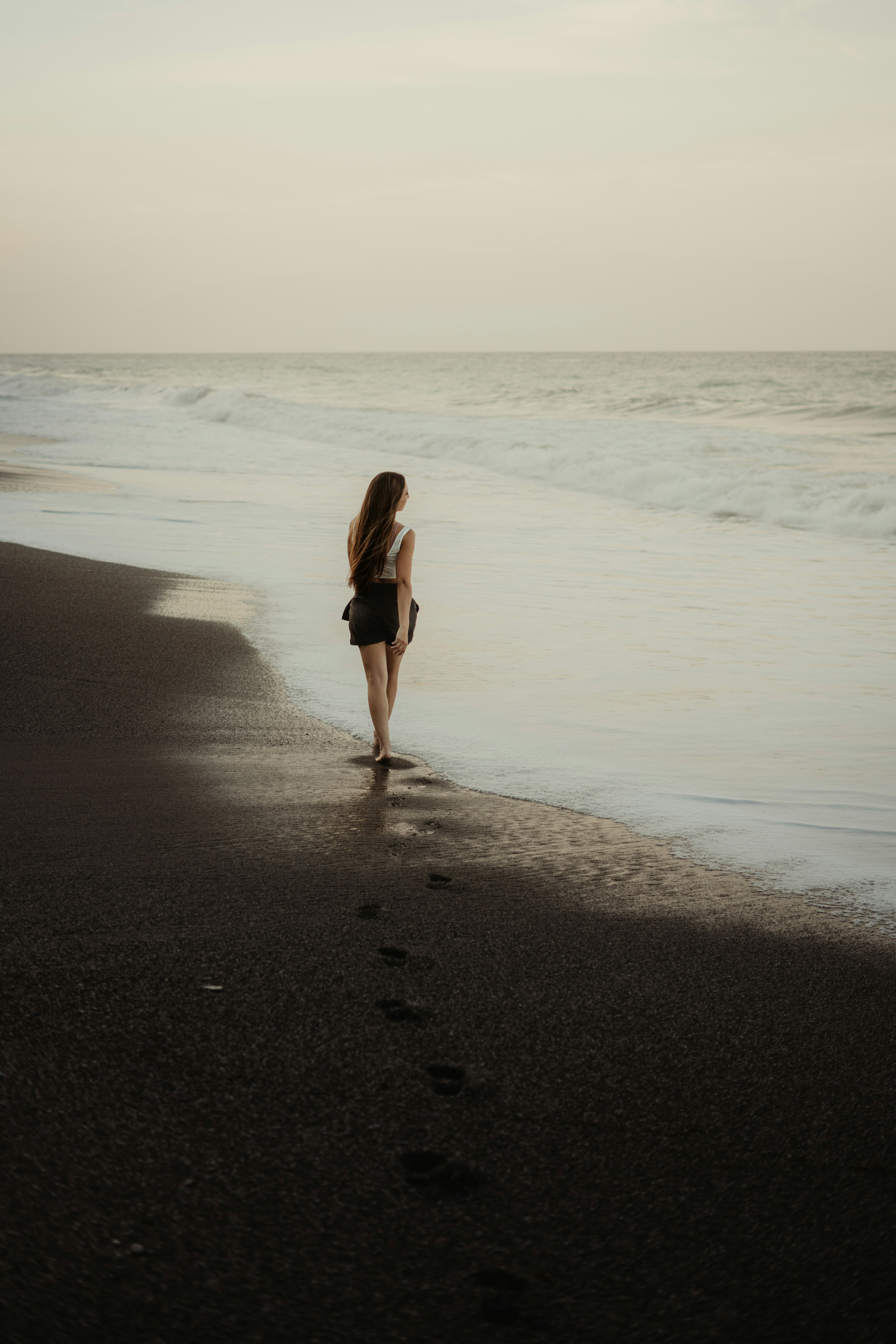 Footsteps to the Tide: A lone wanderer on a quiet shoreline